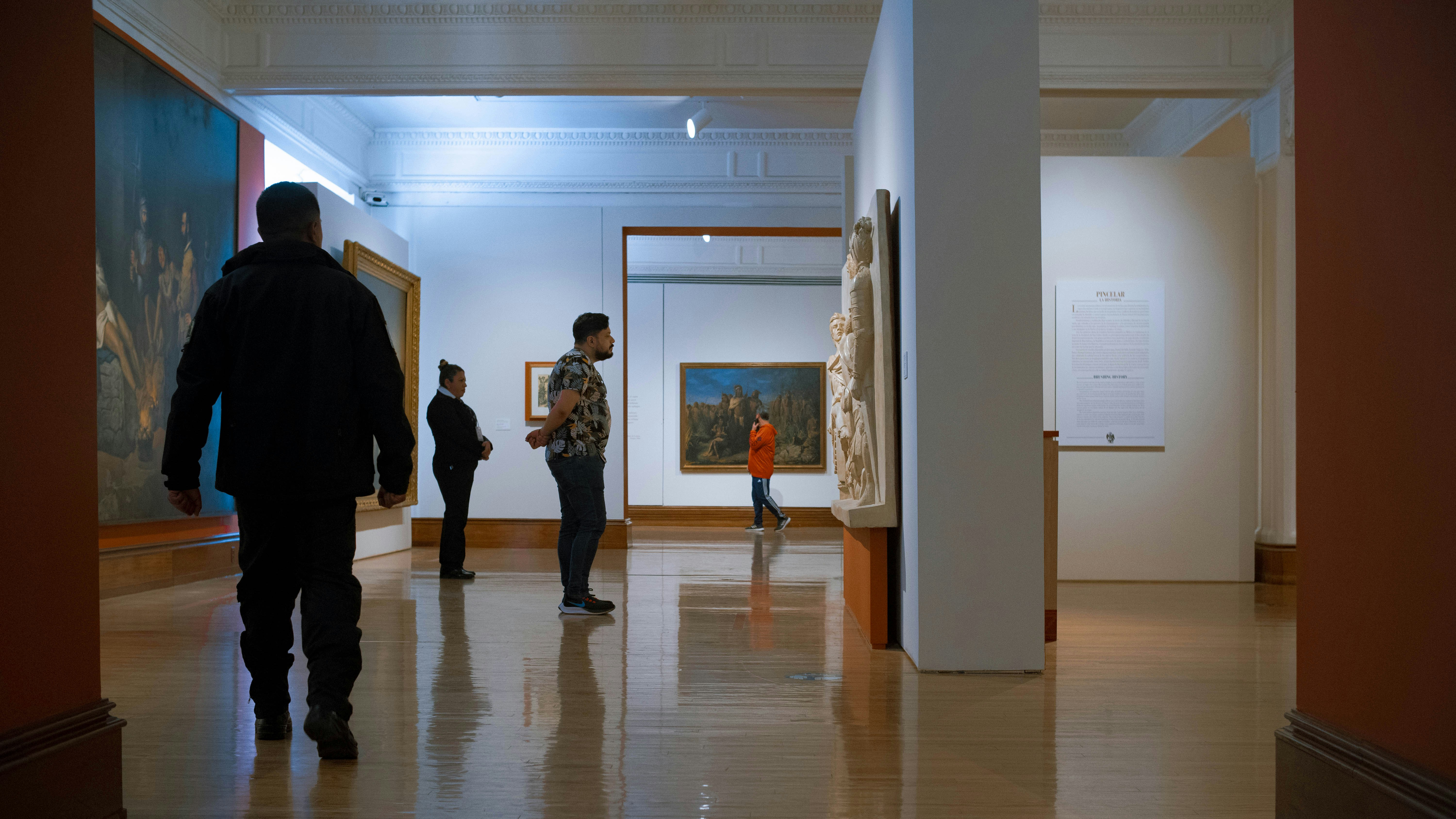 People wander through an art gallery, admiring artwork. photo – Free ...