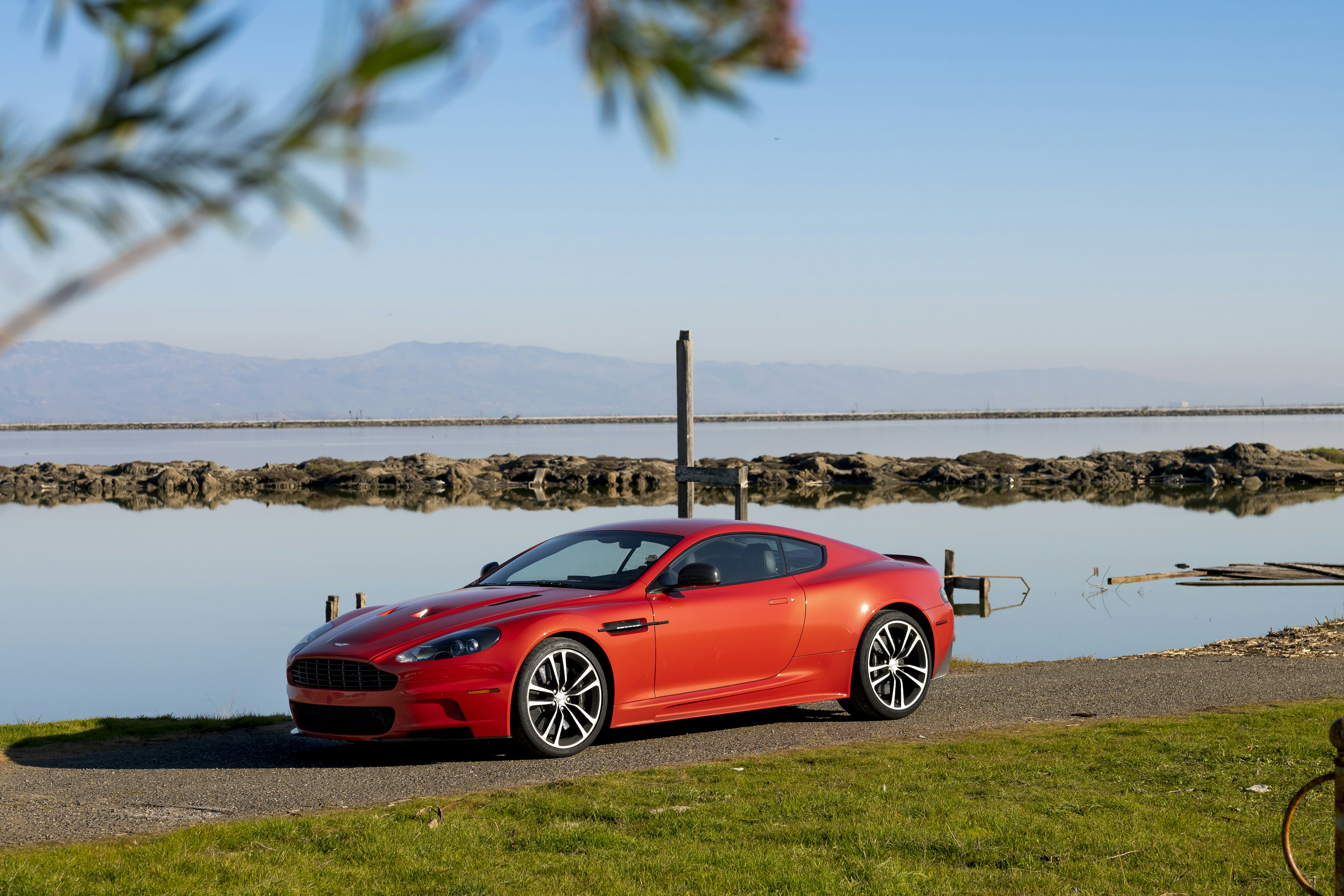 Red Aston on the Lakefront: A Sunny Convertible by the Quiet Mooring