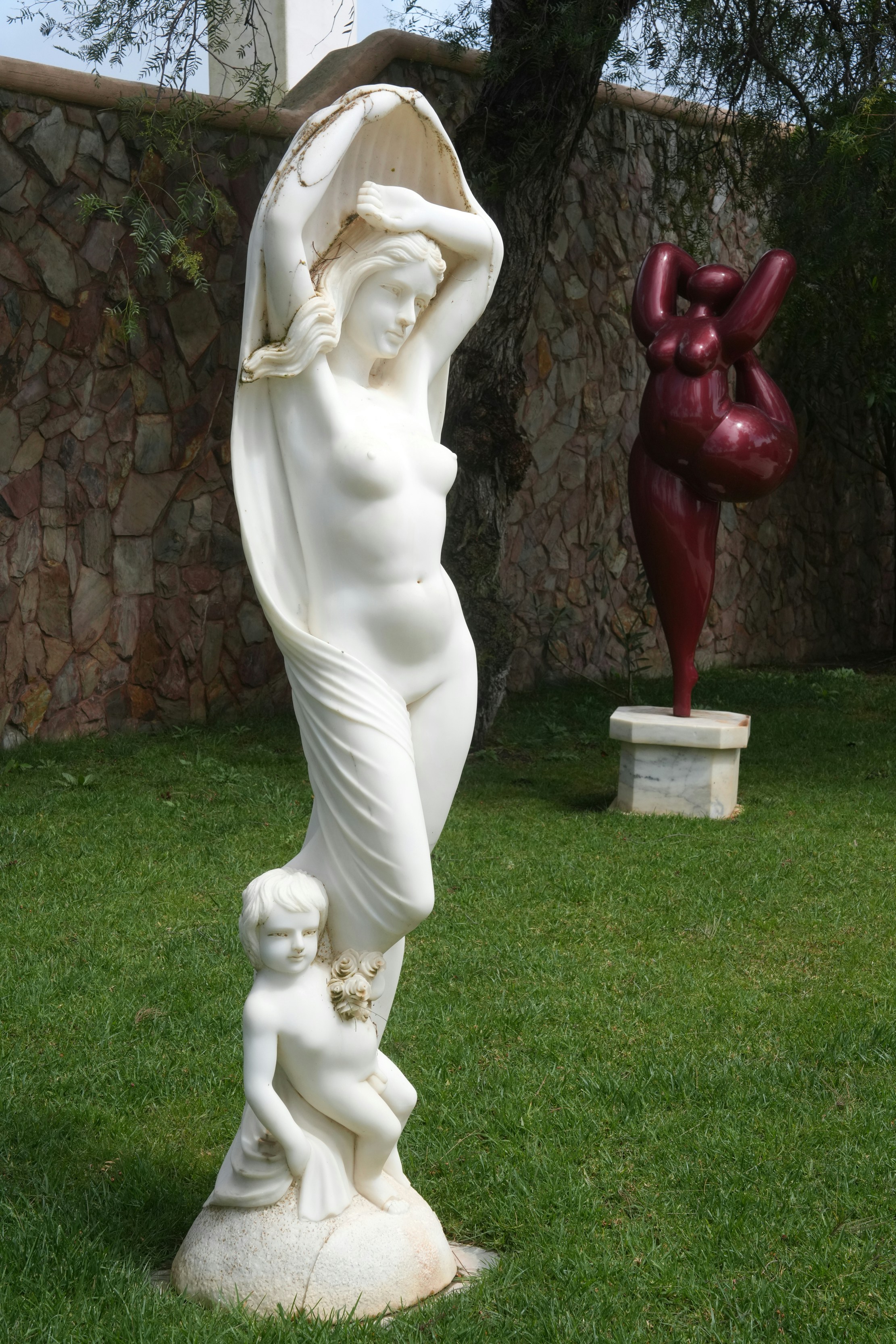 Marble Maiden in a Garden of Contrasts: White Grace Against Crimson Echoes