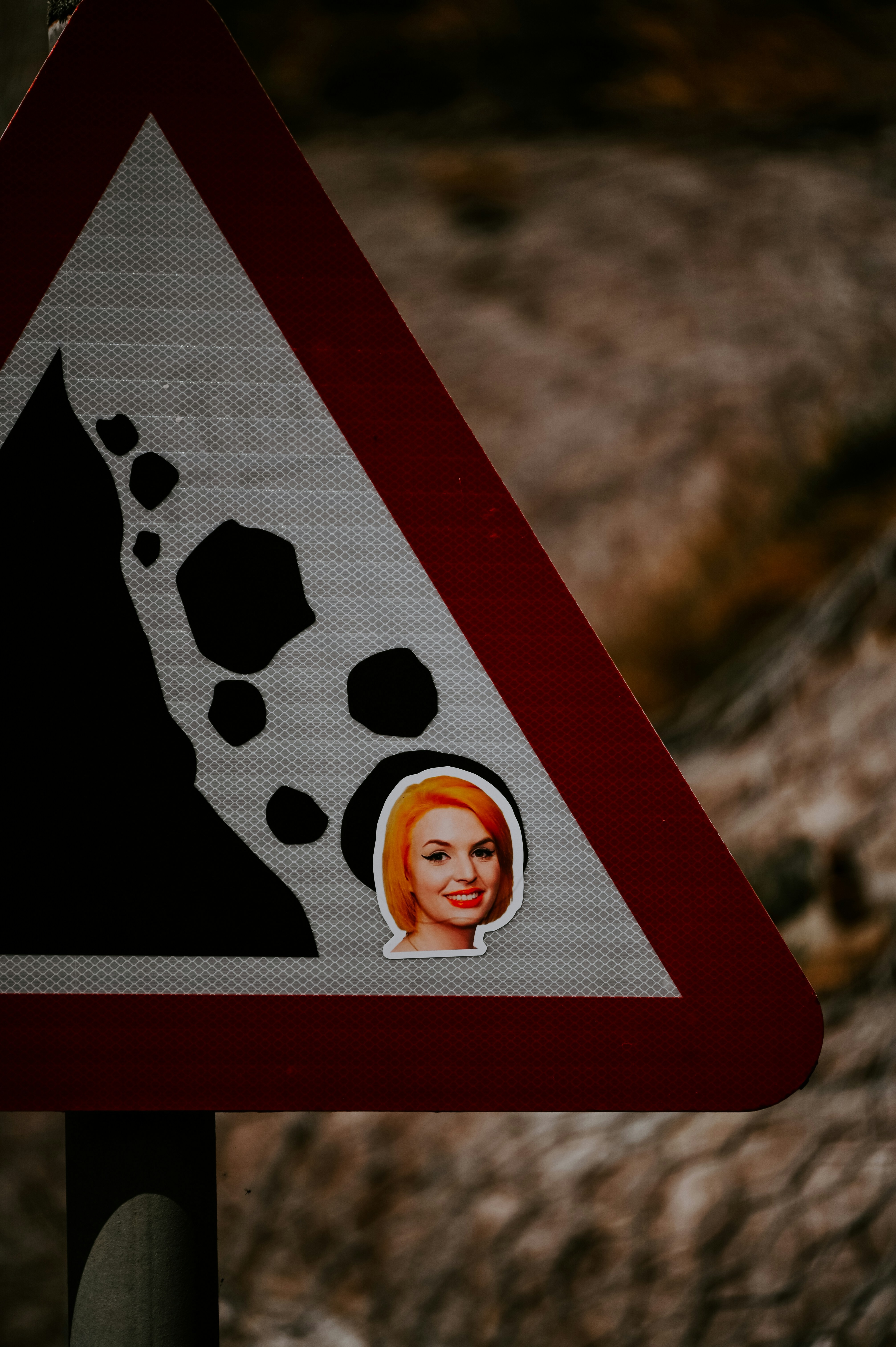 Stickered Signpost: A Small Pop of Color Anchors the Triangle of Warning
