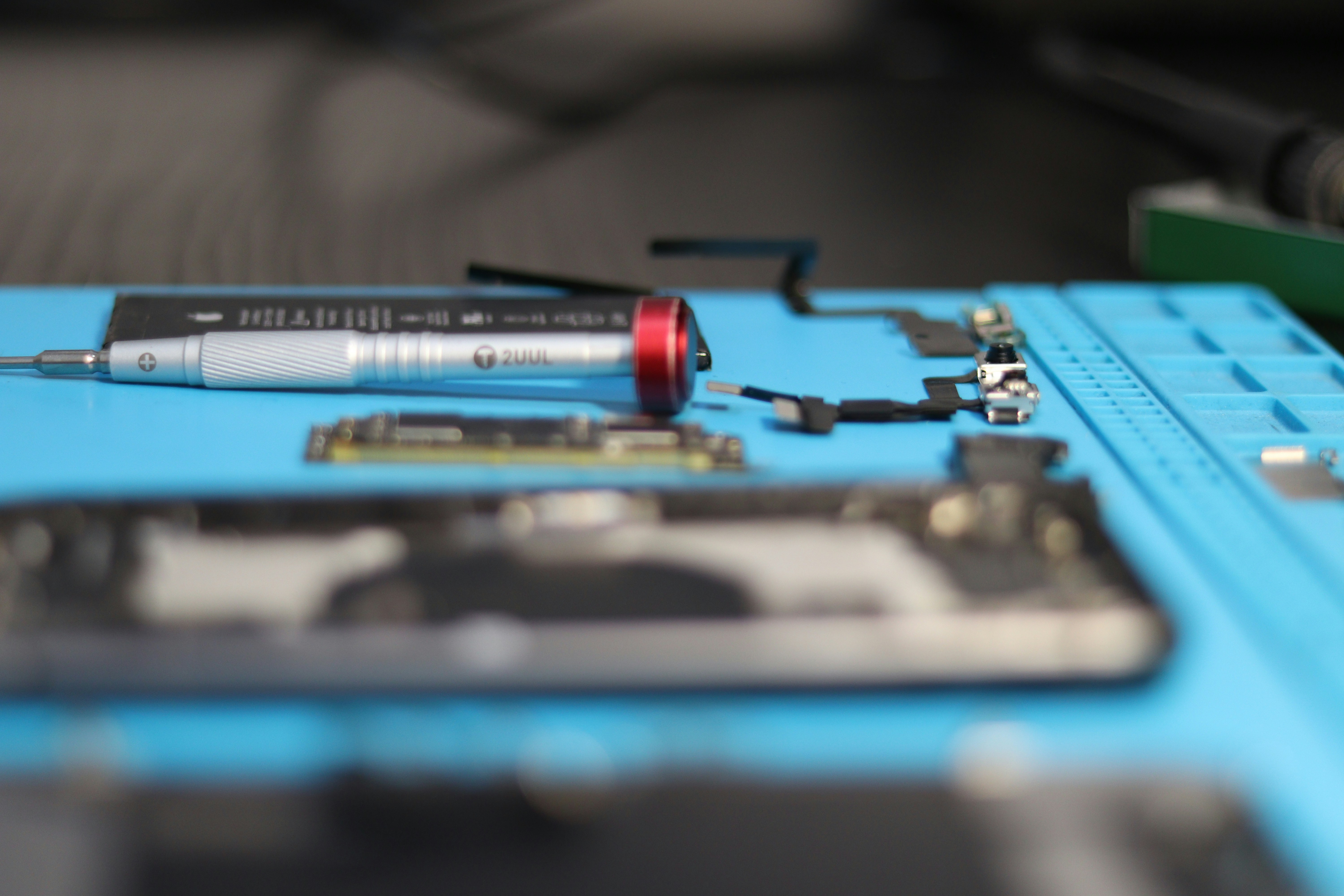 Red-capped Precision Screwdriver Resting on a Bright Blue Work Mat
