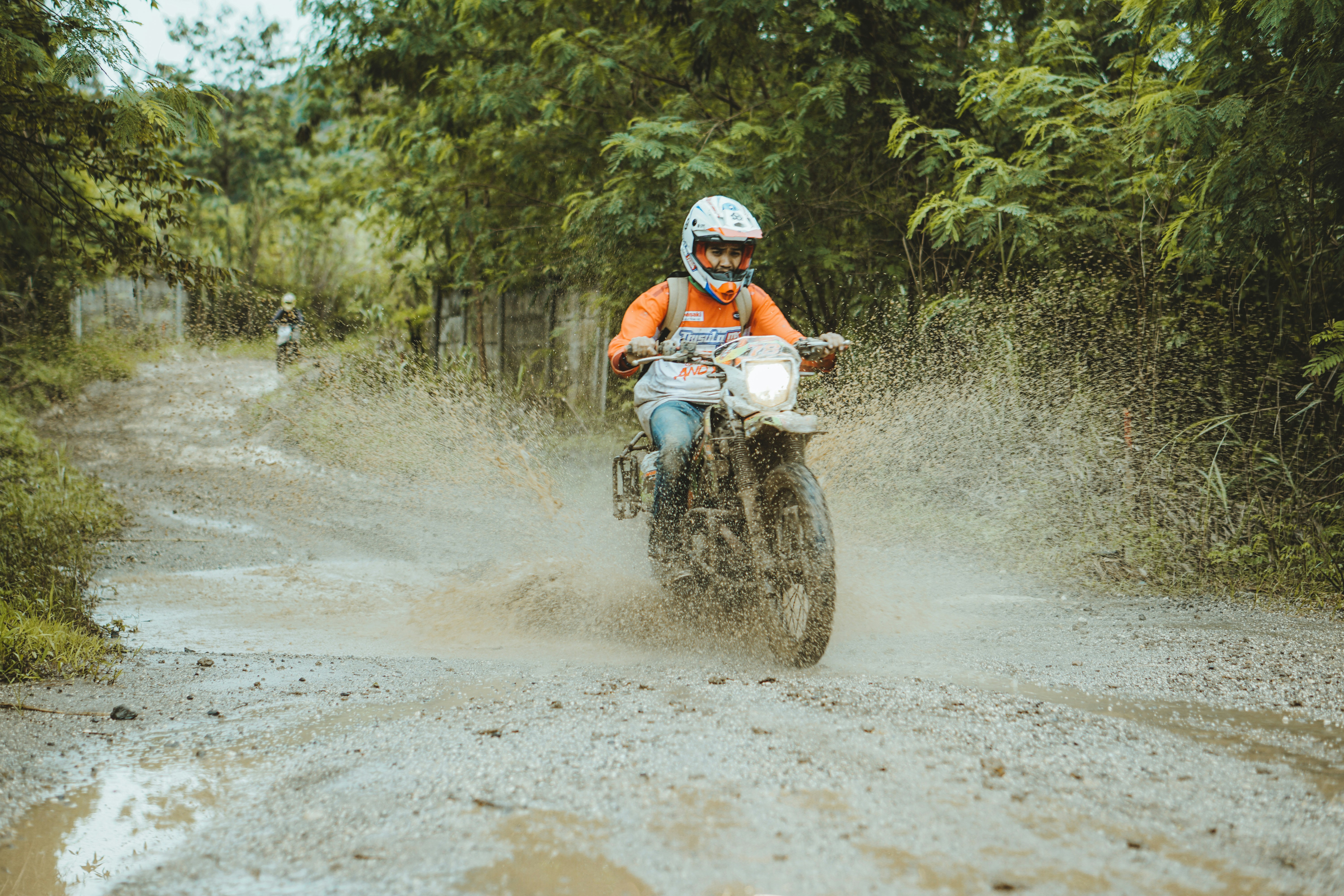 Motorcyclist rides through muddy water on dirt road. photo – Free ...