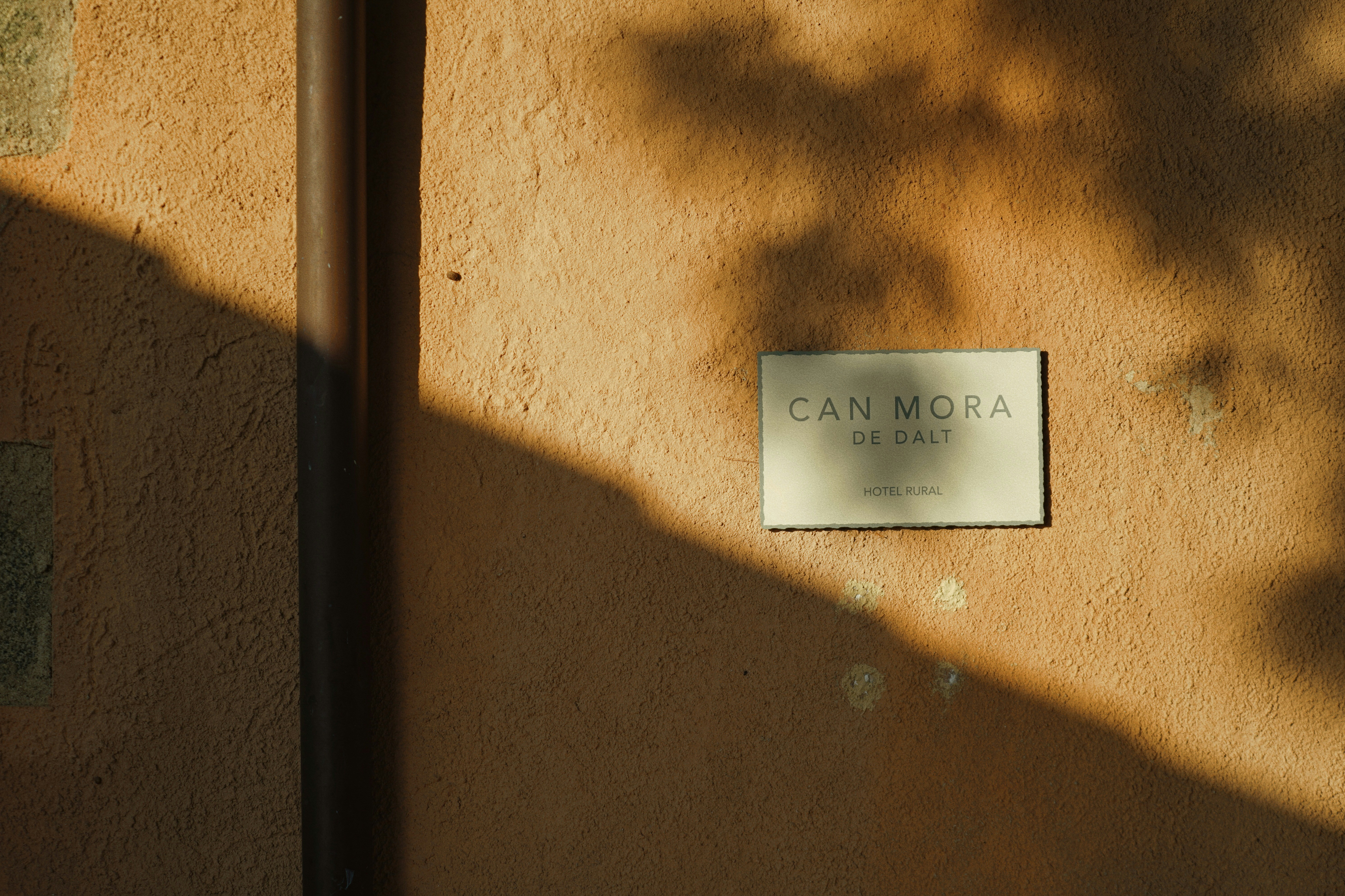 A sign reads "can mora" on a building's wall. photo – Free Sun Image on ...
