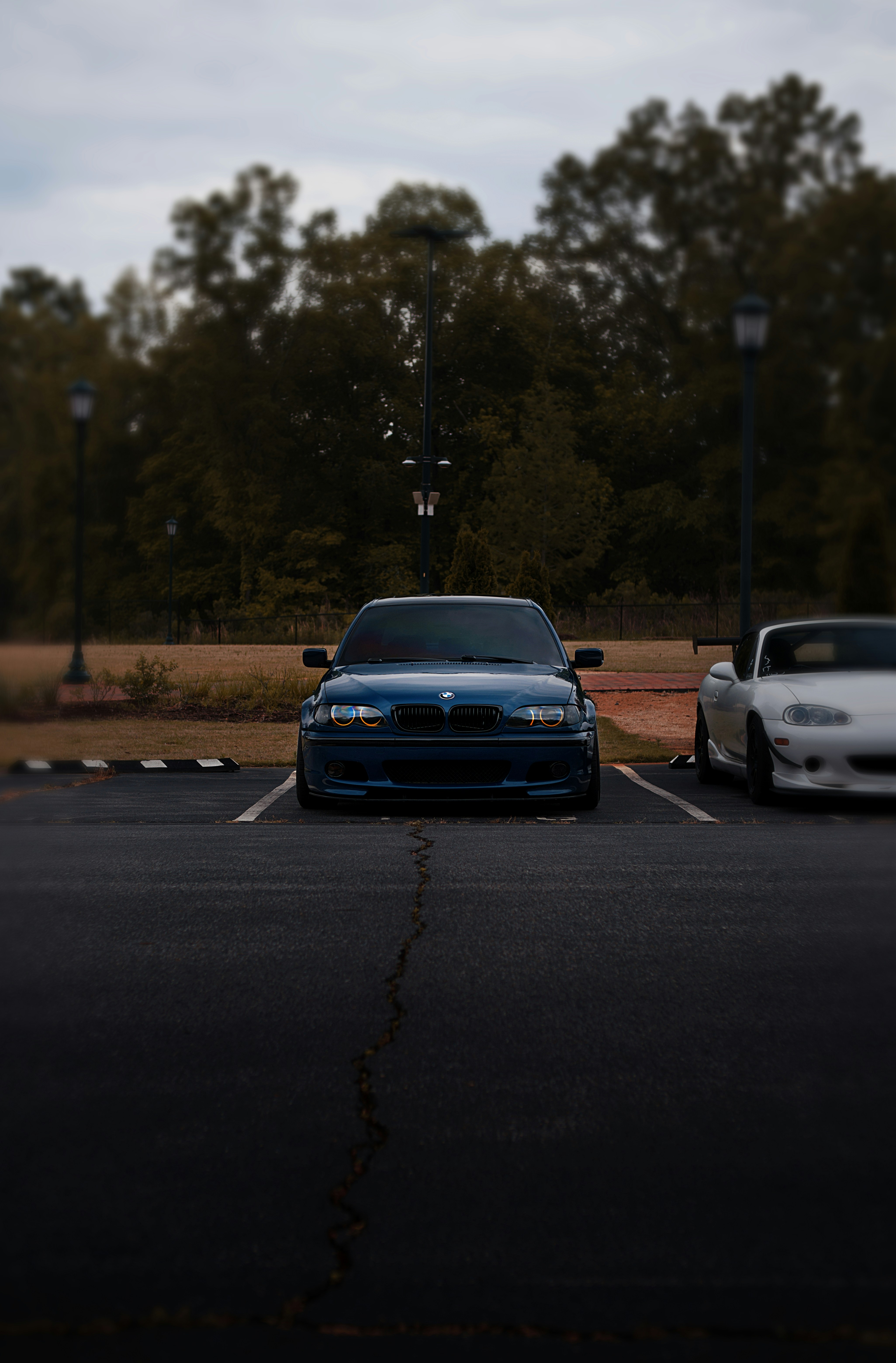 A blue BMW and a white miata parked. photo – Free Usa Image on Unsplash