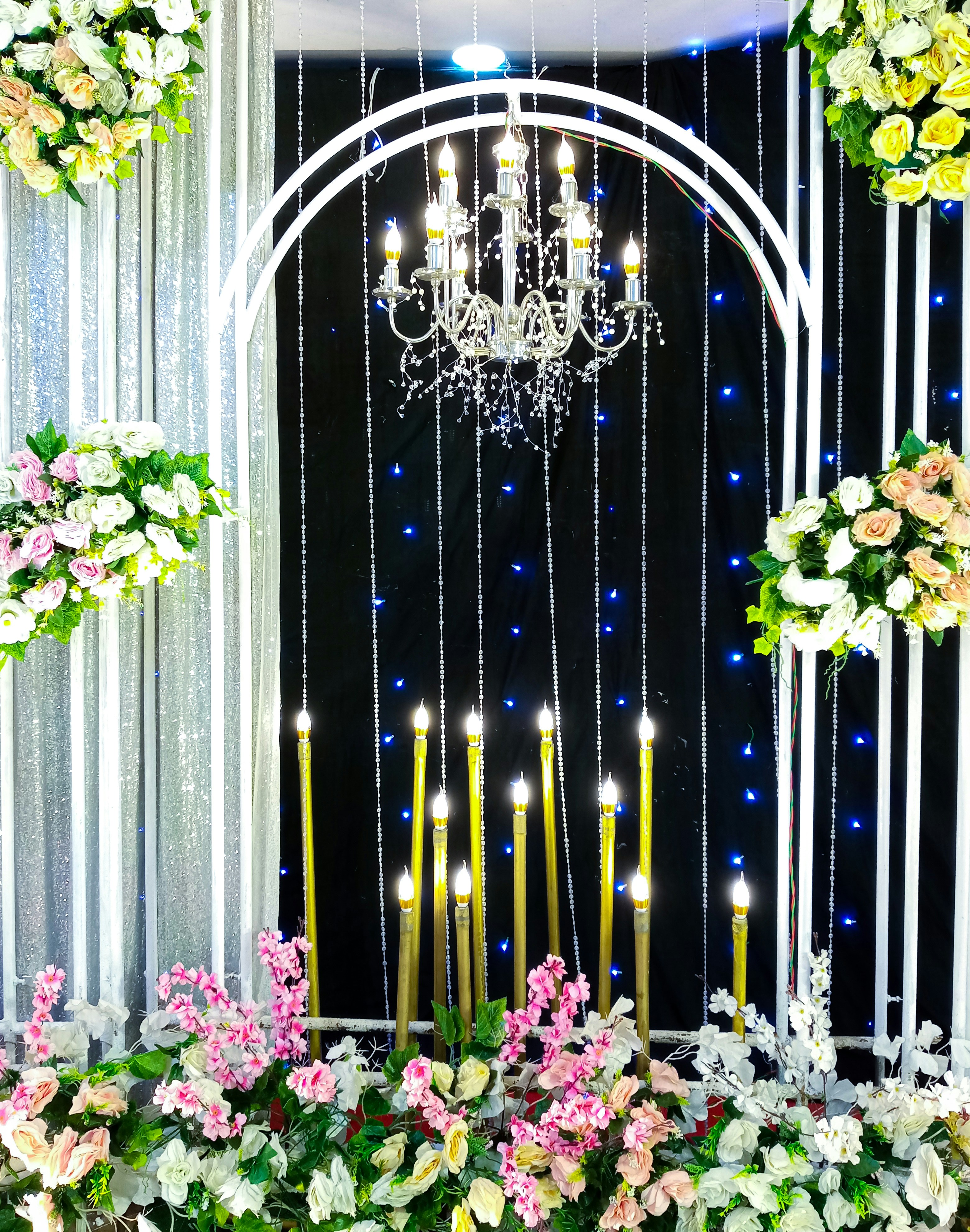 Candlelit Floral Arch Framing a Crystal Chandelier