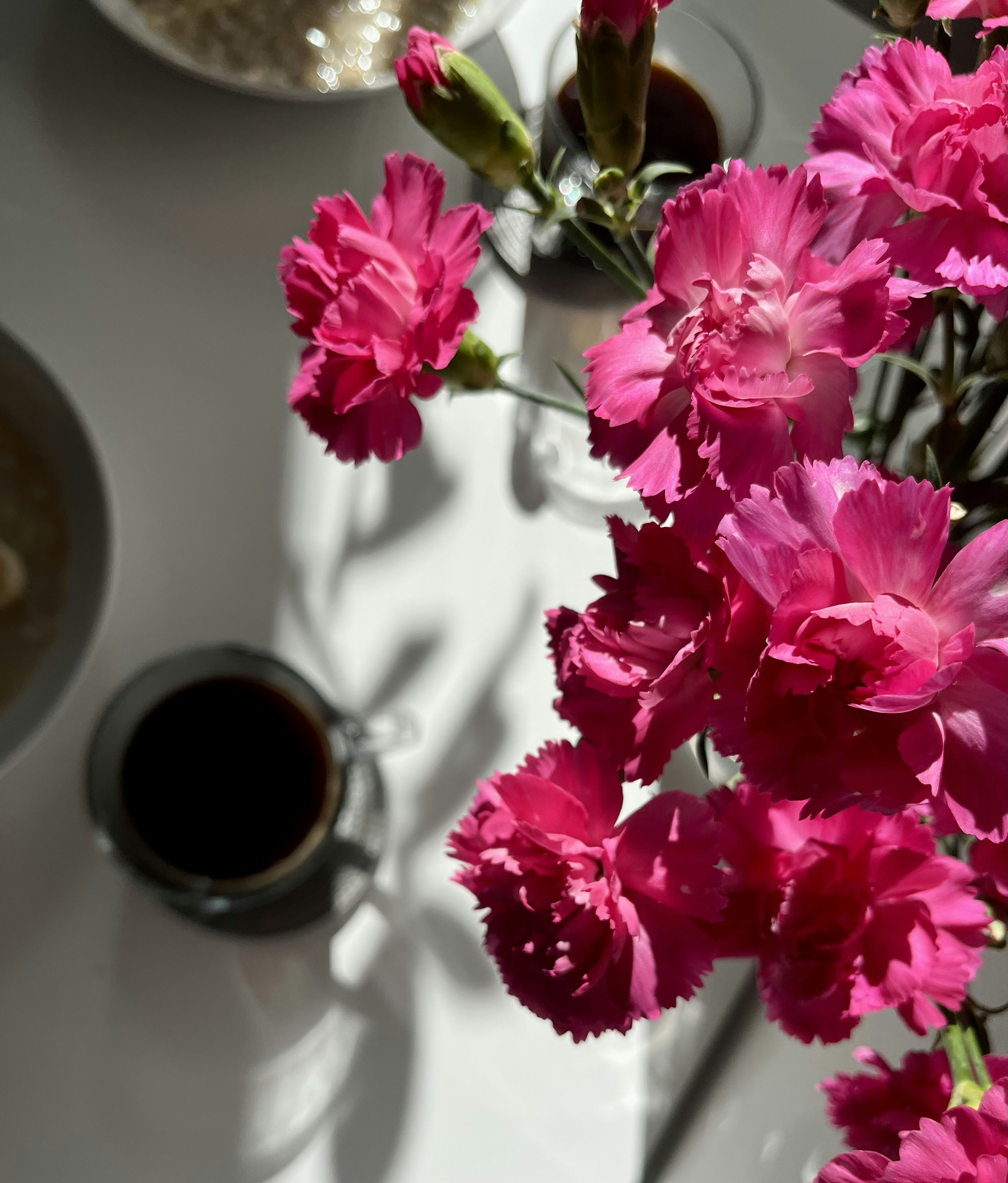 Claveles de color rosa brillante se sientan junto al café. foto ...