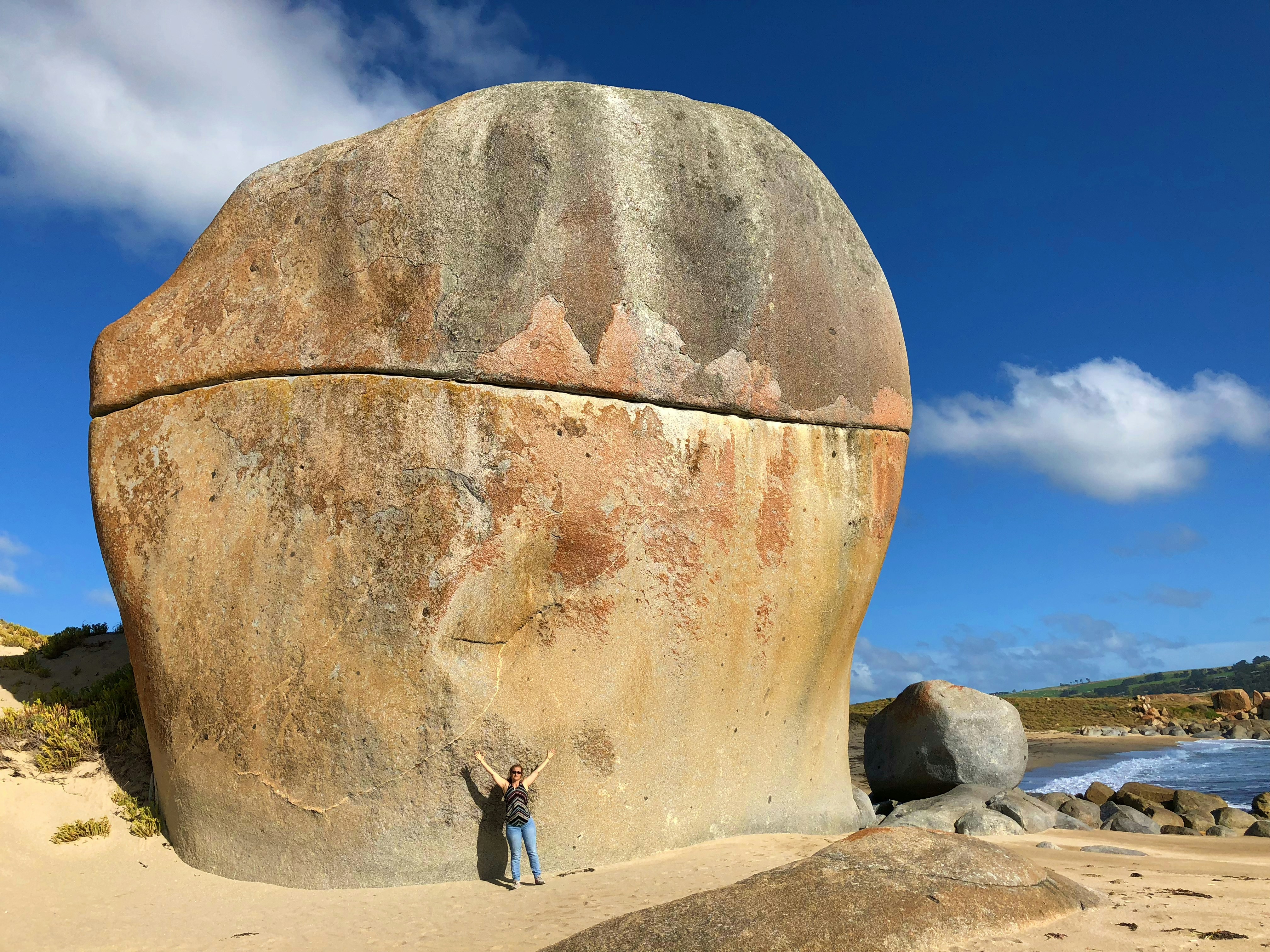 Stone Colossus at the Shore: A Silhouette Reaches Toward the Sky at a Weathered Monolith