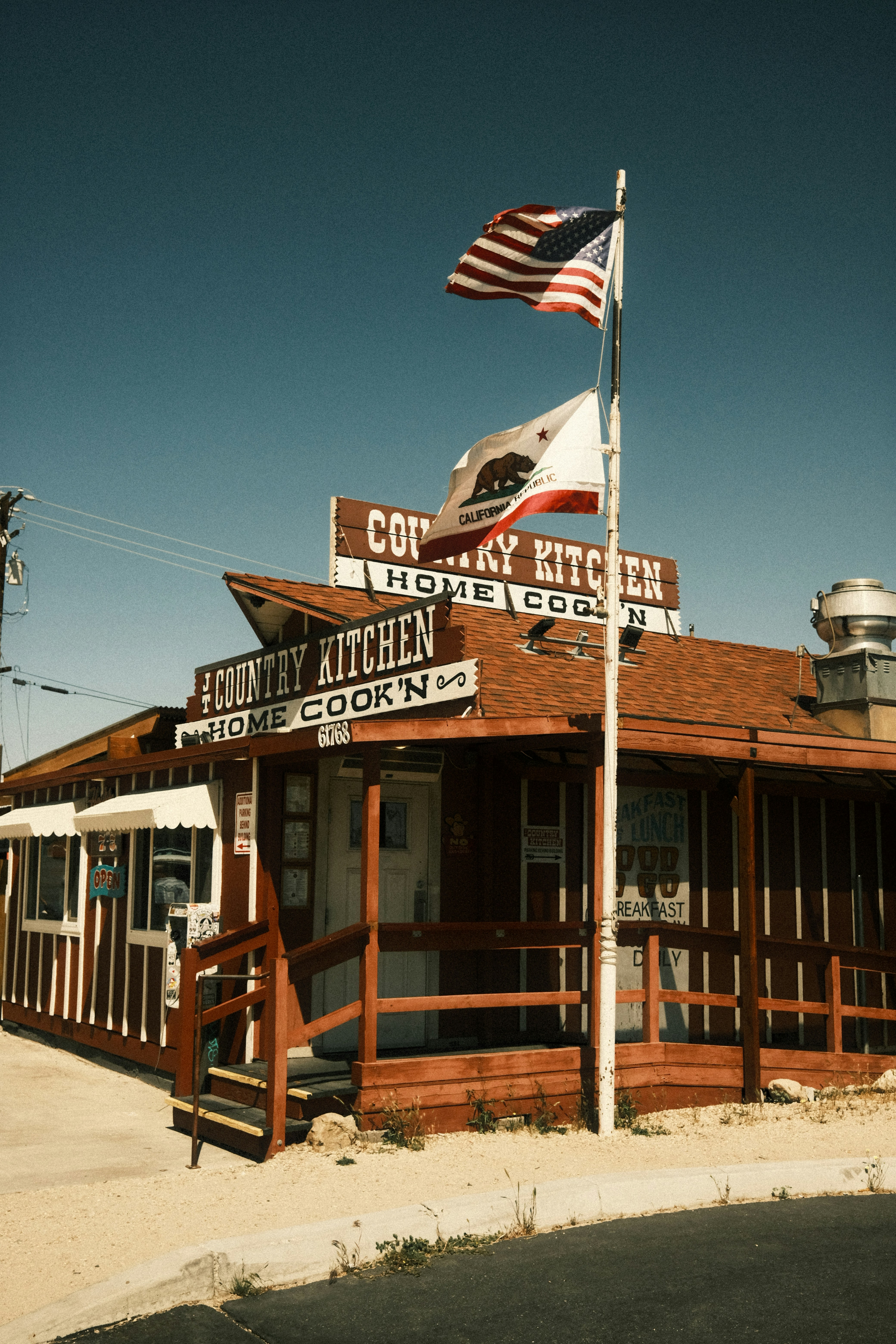 Desert Diner Corner: Weathered Wood, Flags, and Sunlit Signage