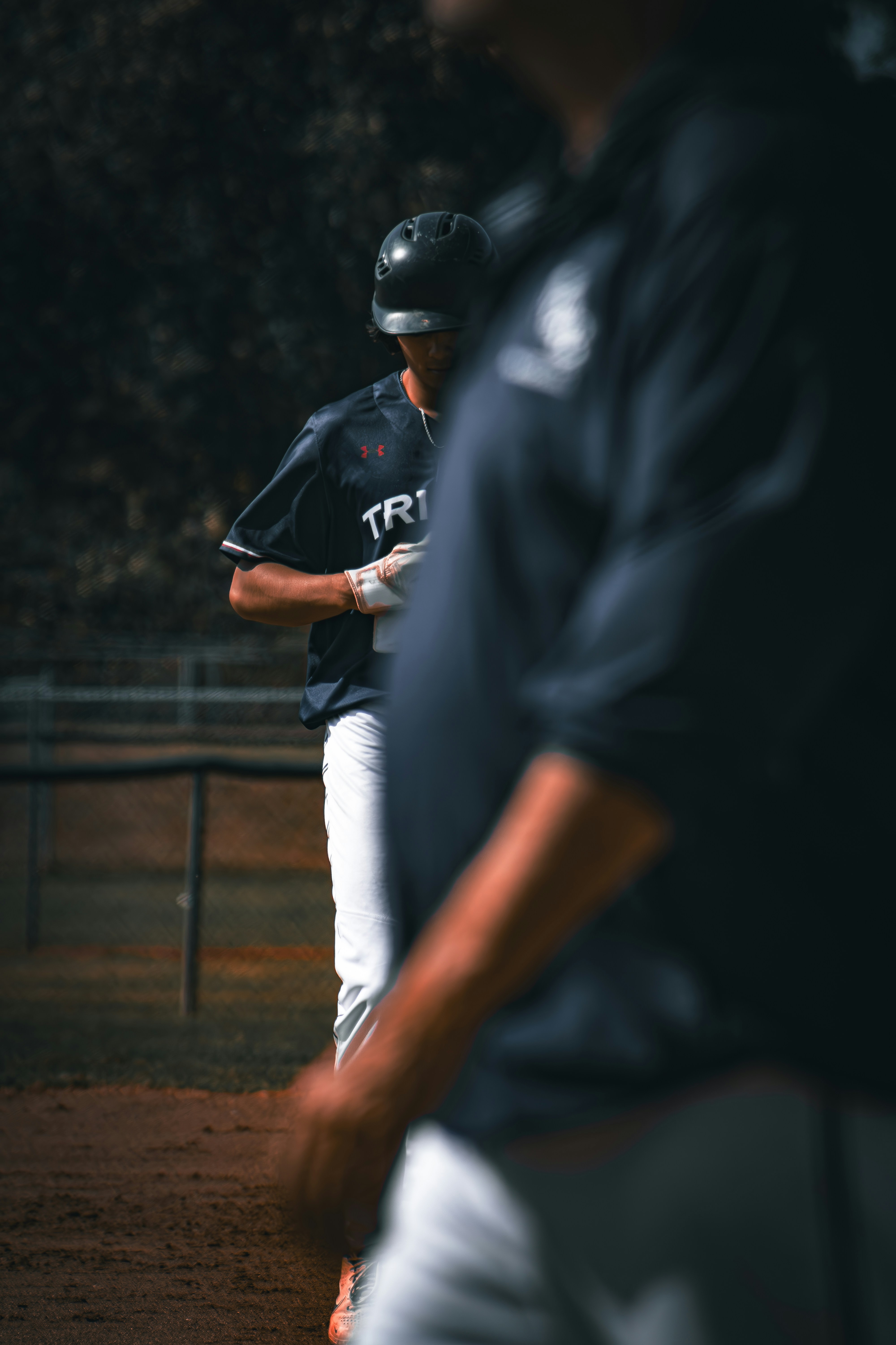 Helmeted Pause in the Shadowed Dugout