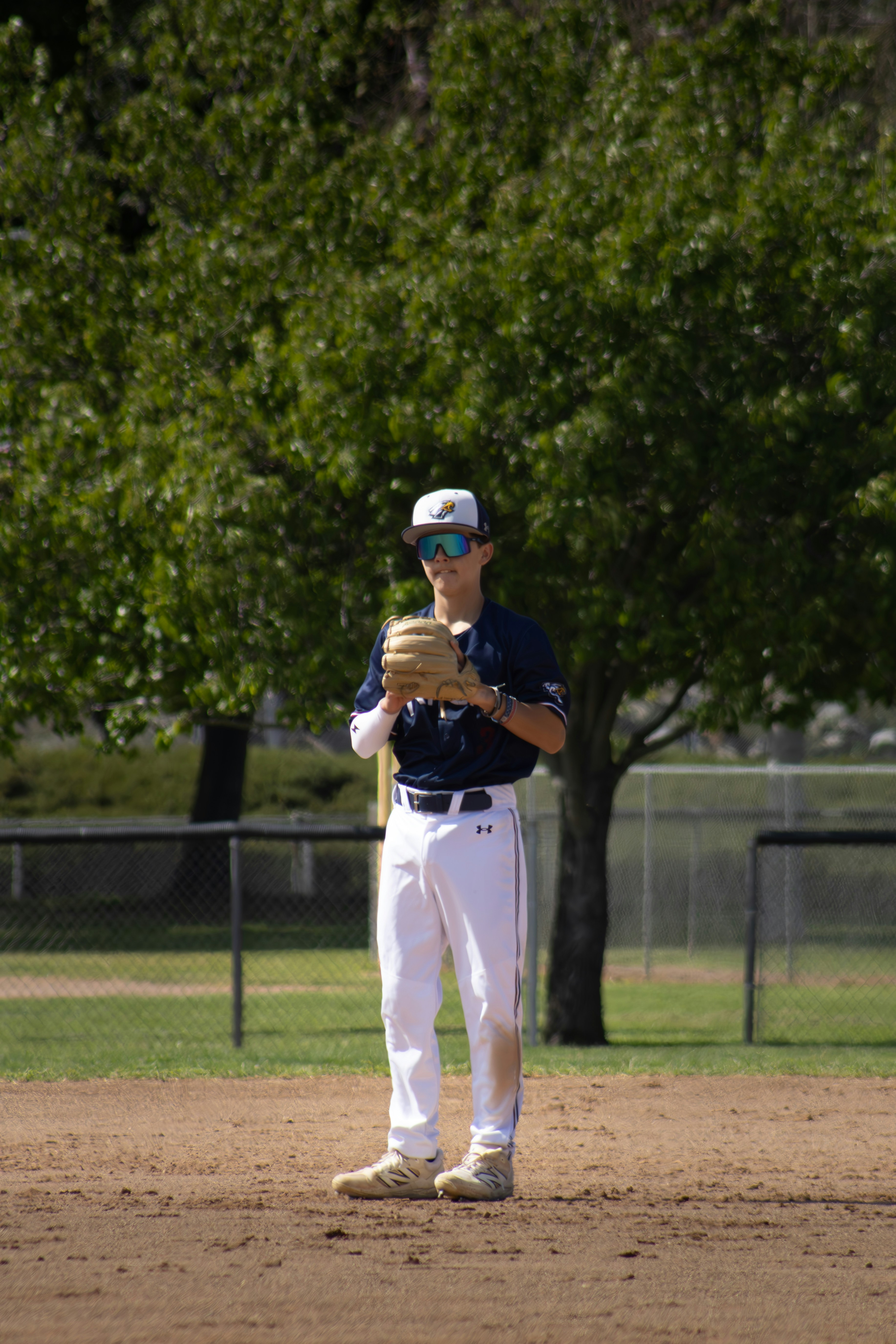 Baseball player standing on a field, holding a glove. photo – Free ...