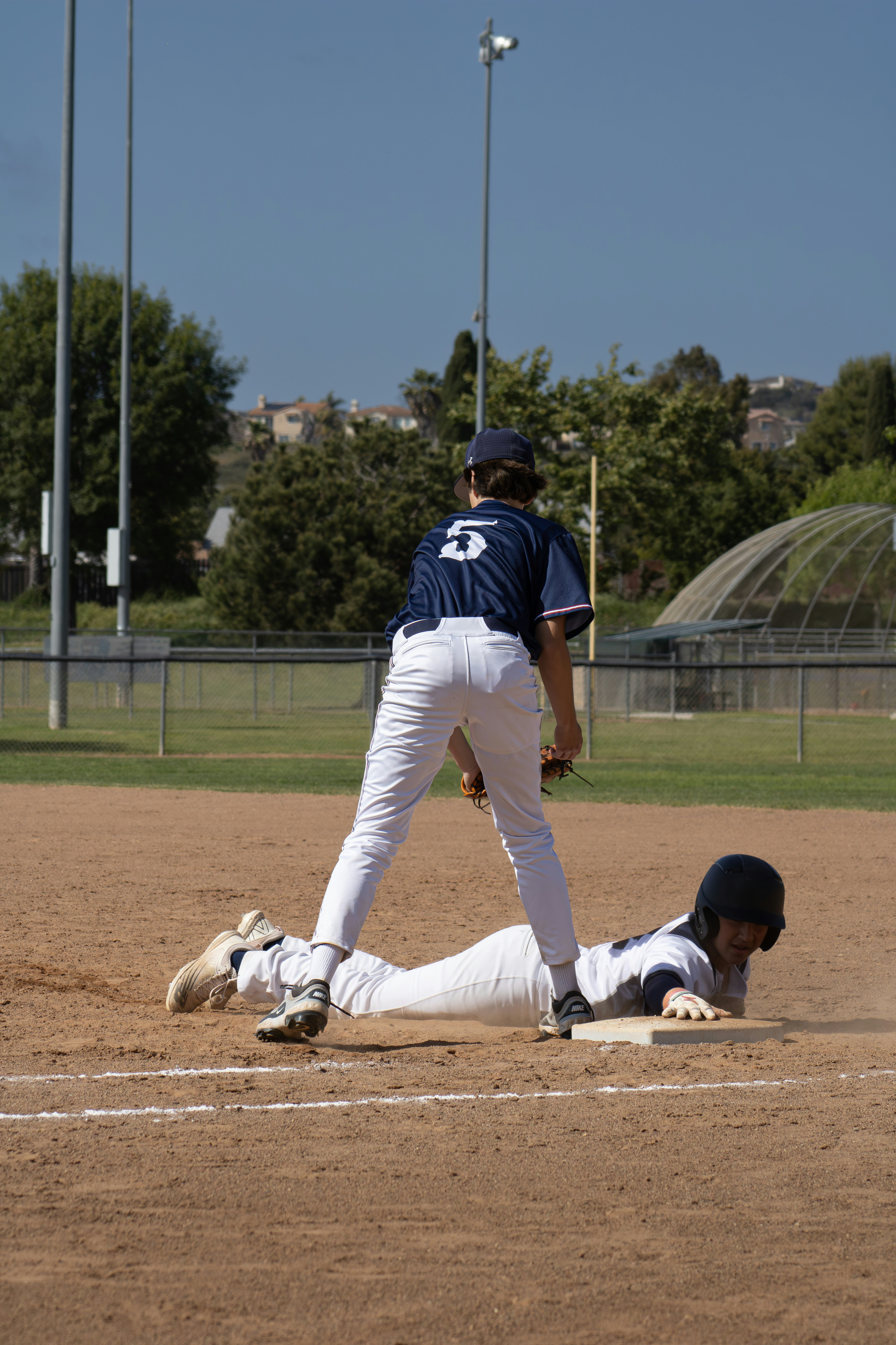 Baseball player slides into a base while another watches. photo – Free ...