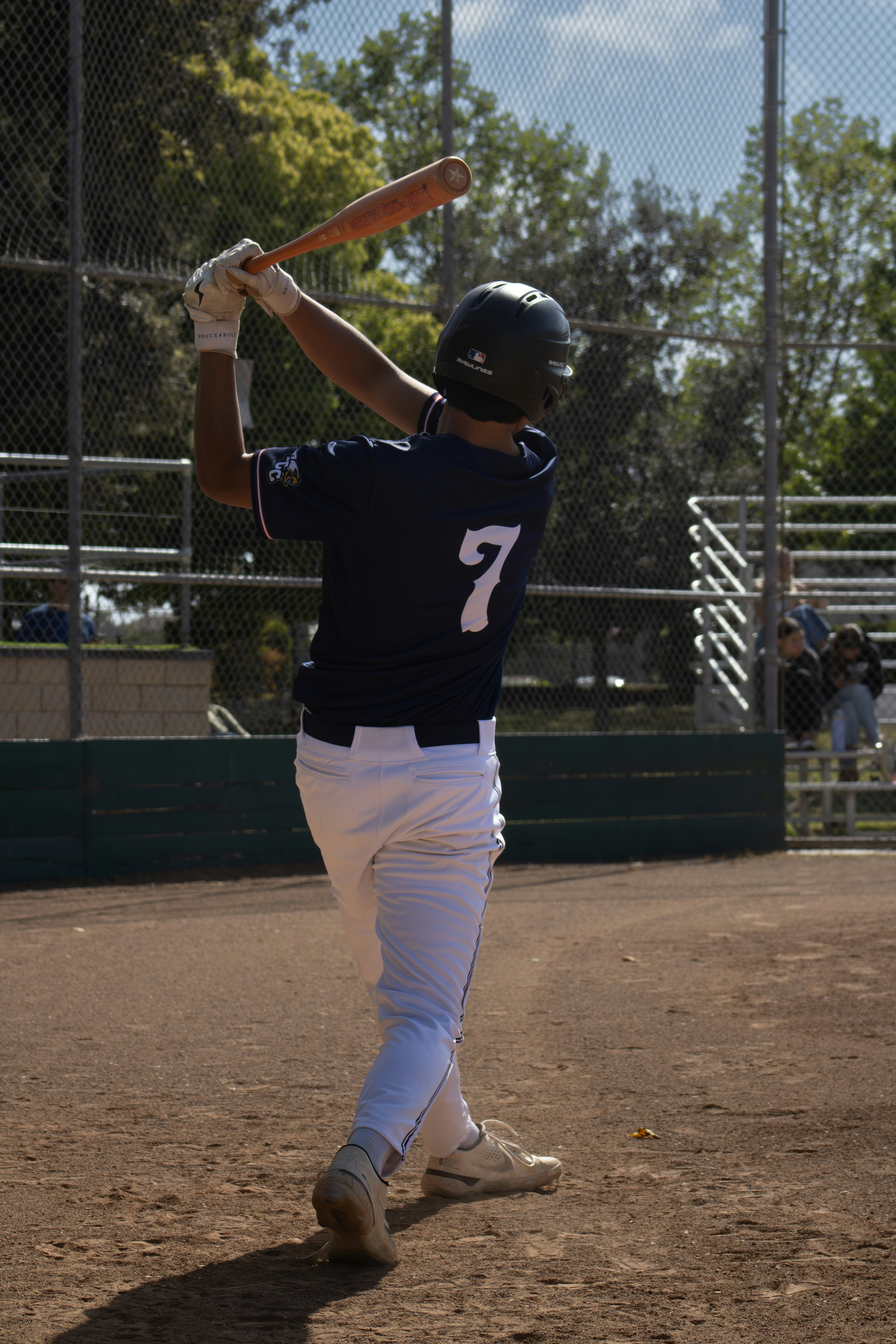 Mid-Swing in Blue: a batter's decisive arc under the sunlit diamond