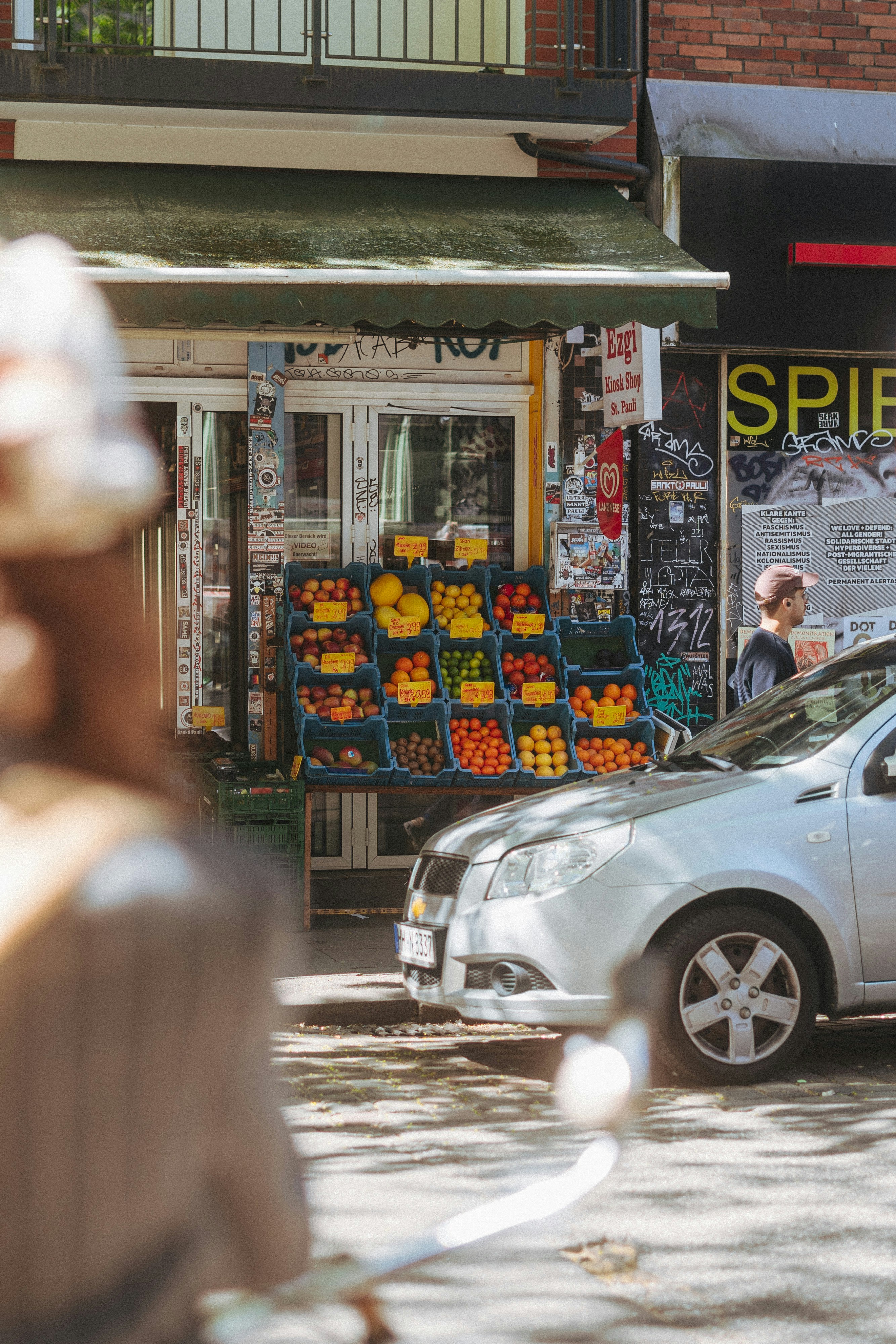 Street Market Fruit Stand Framed by Passing Vehicle