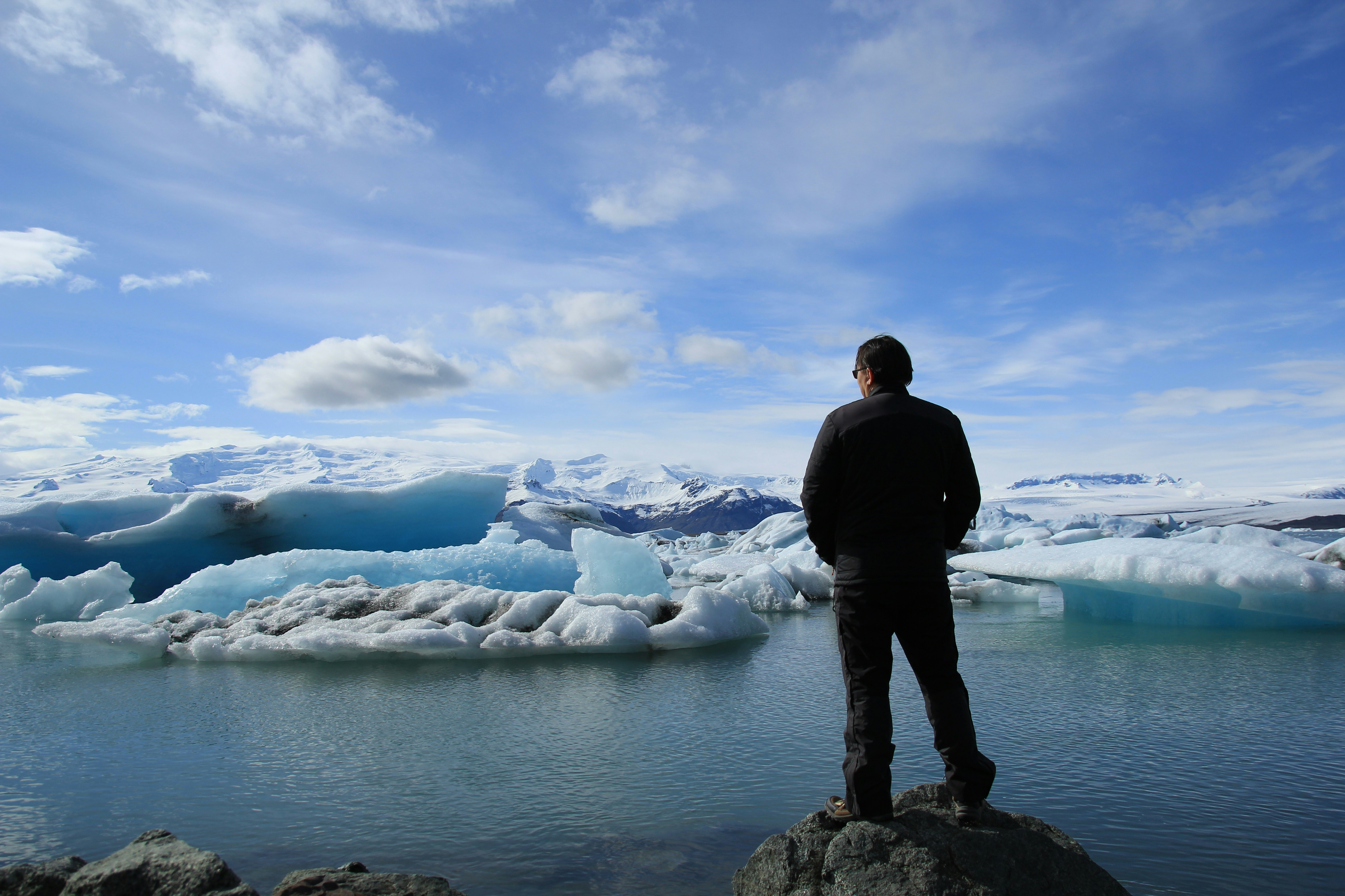 Stand on the Edge: A Lone Observer Before a Glacier-Filled Fjord