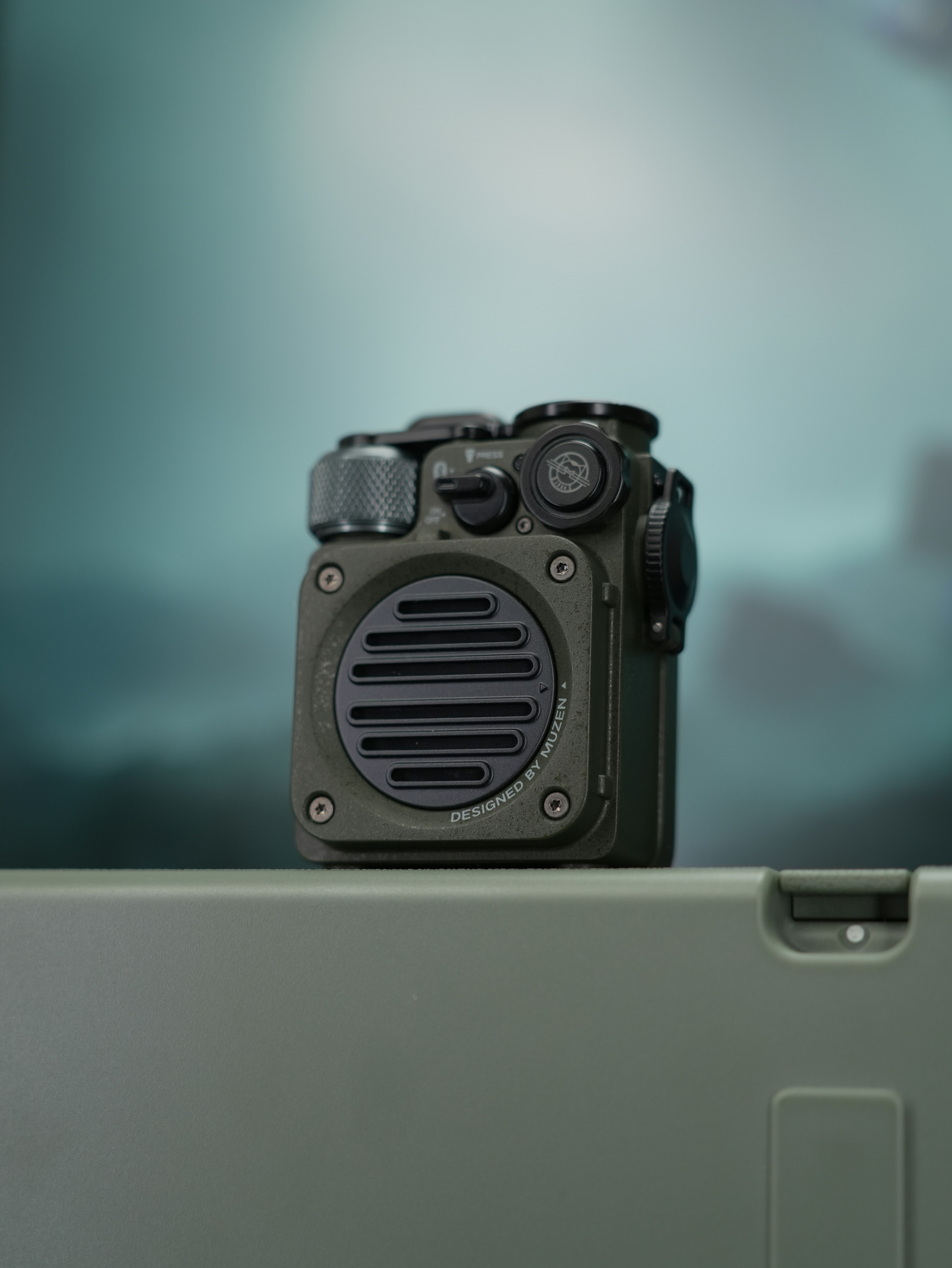 Rugged Compact on a Green Ledge: a close-up study of texture and readiness