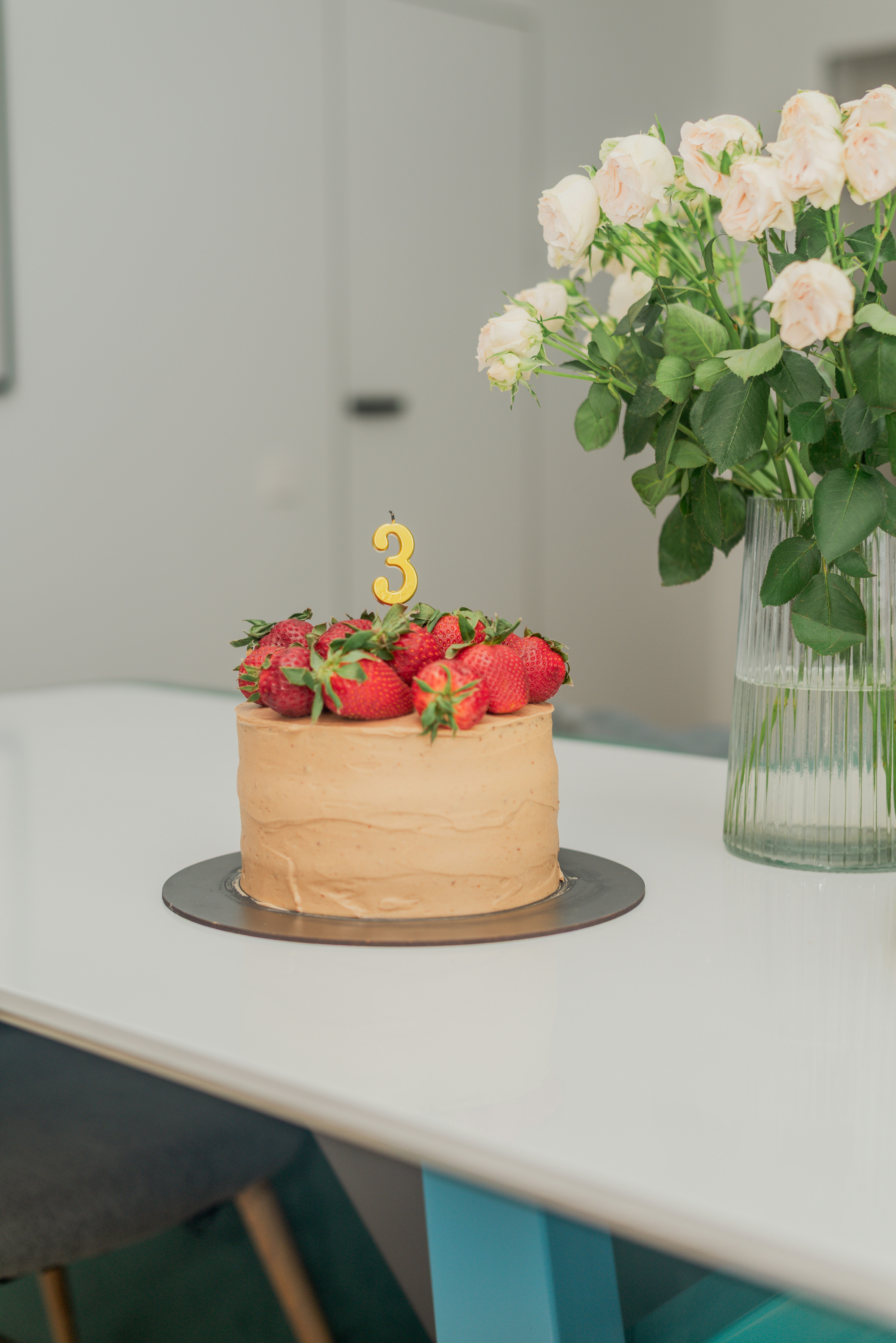 A strawberry cake celebrates a third birthday.