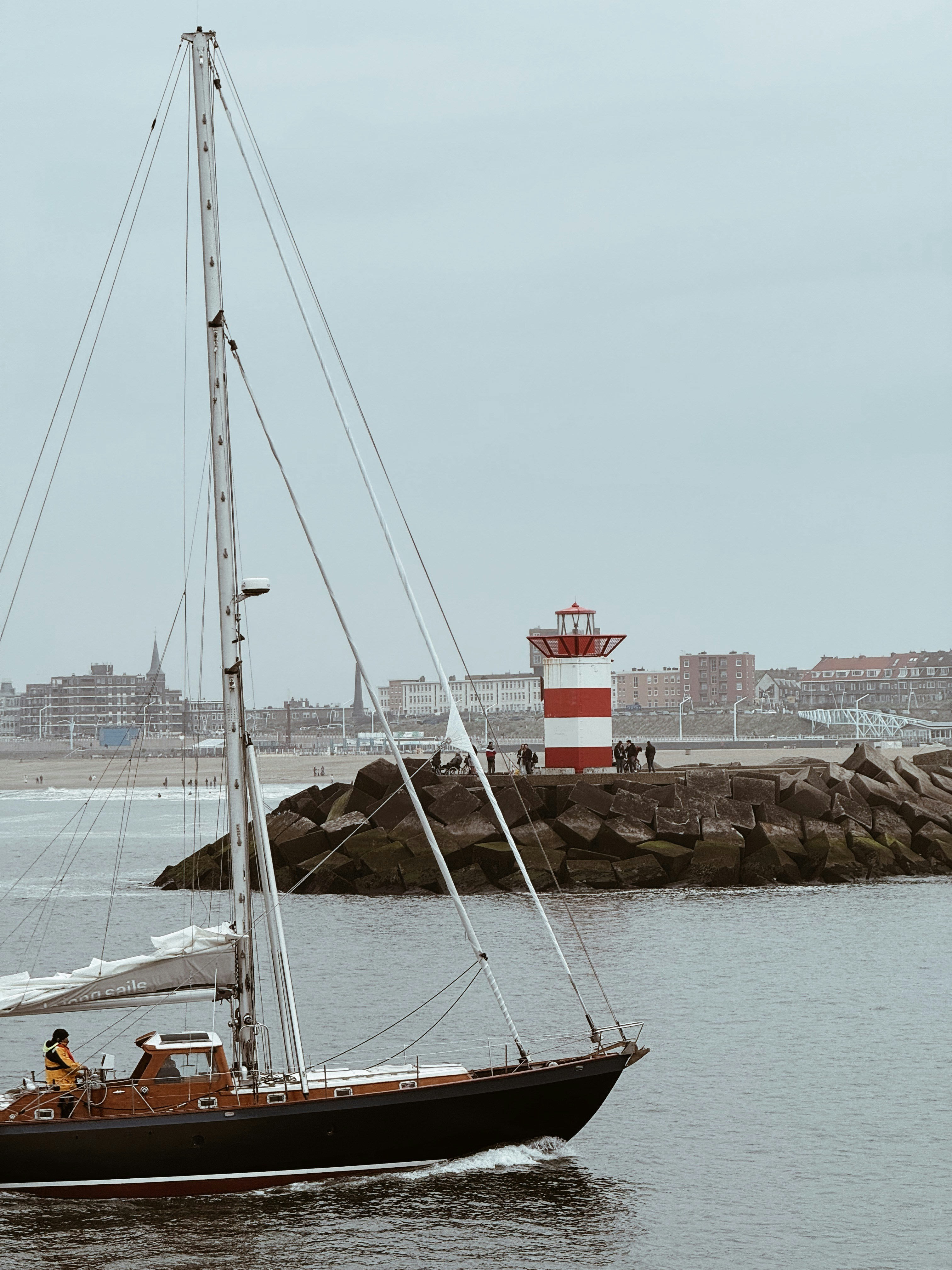 Beacon and Sails: A Harbor Crossing by the Striped Lighthouse