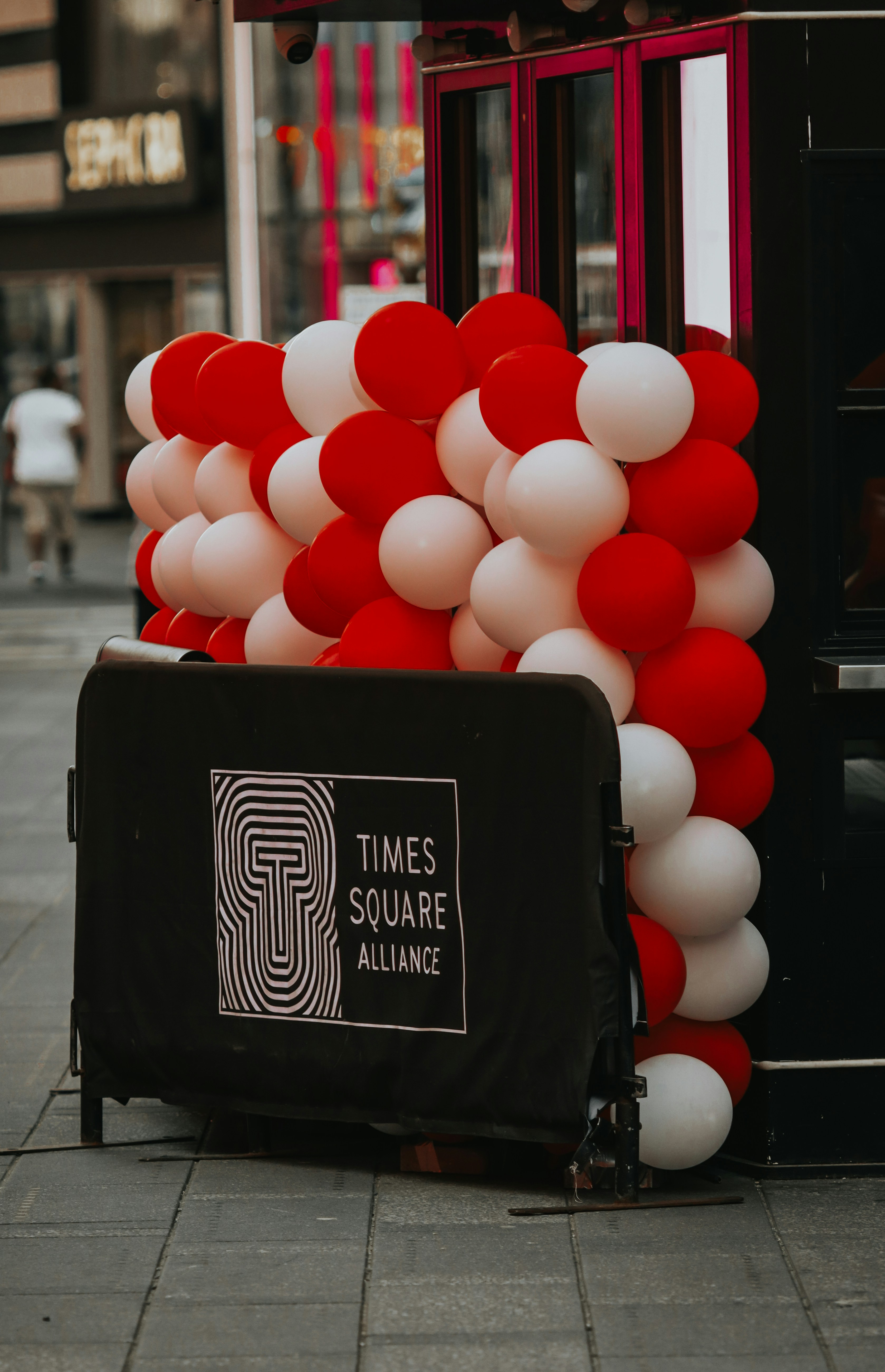 Red-and-White Balloon Arch Framing a Times Square Alliance Panel