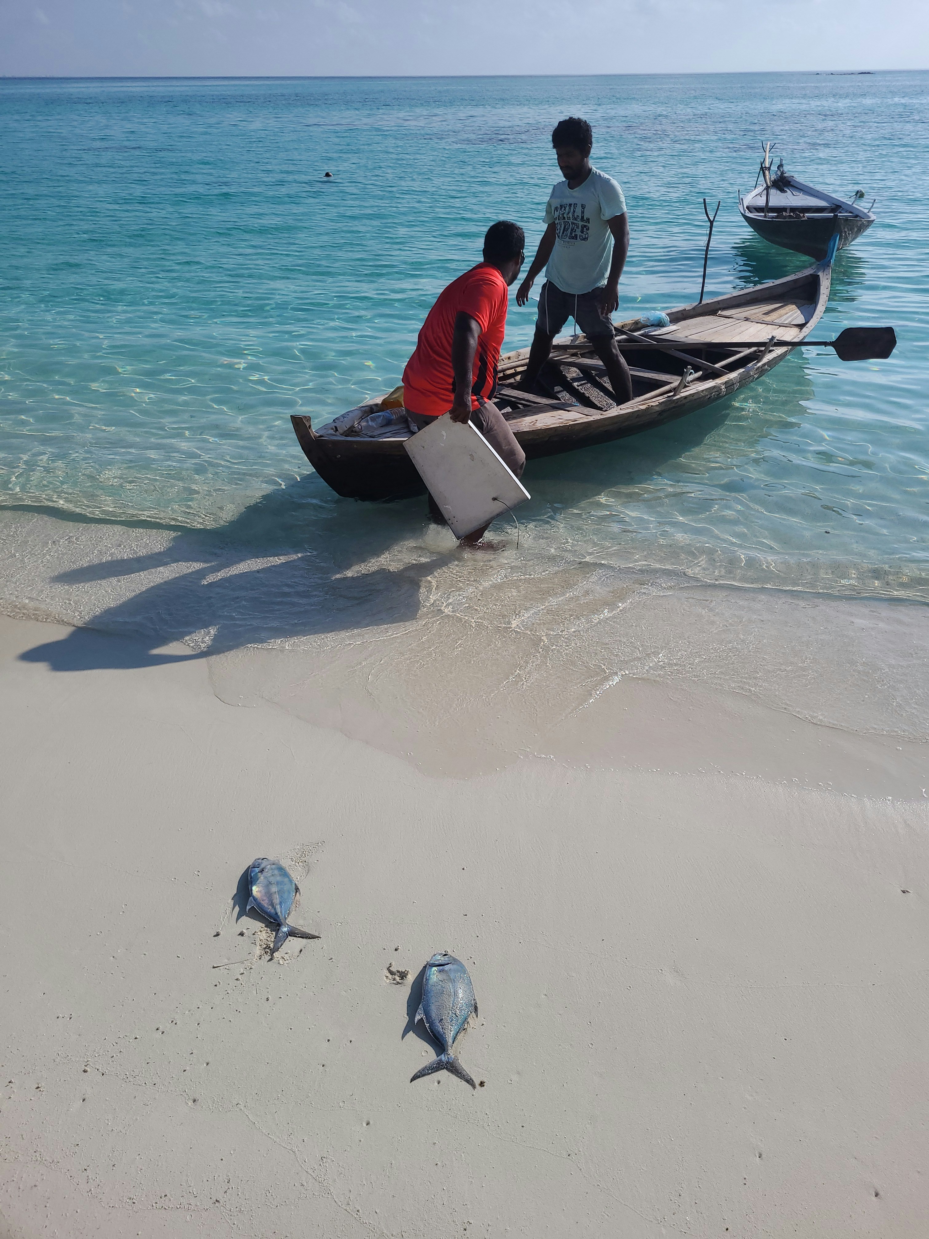 Two Boys in a Wooden Boat at the Turquoise Shore