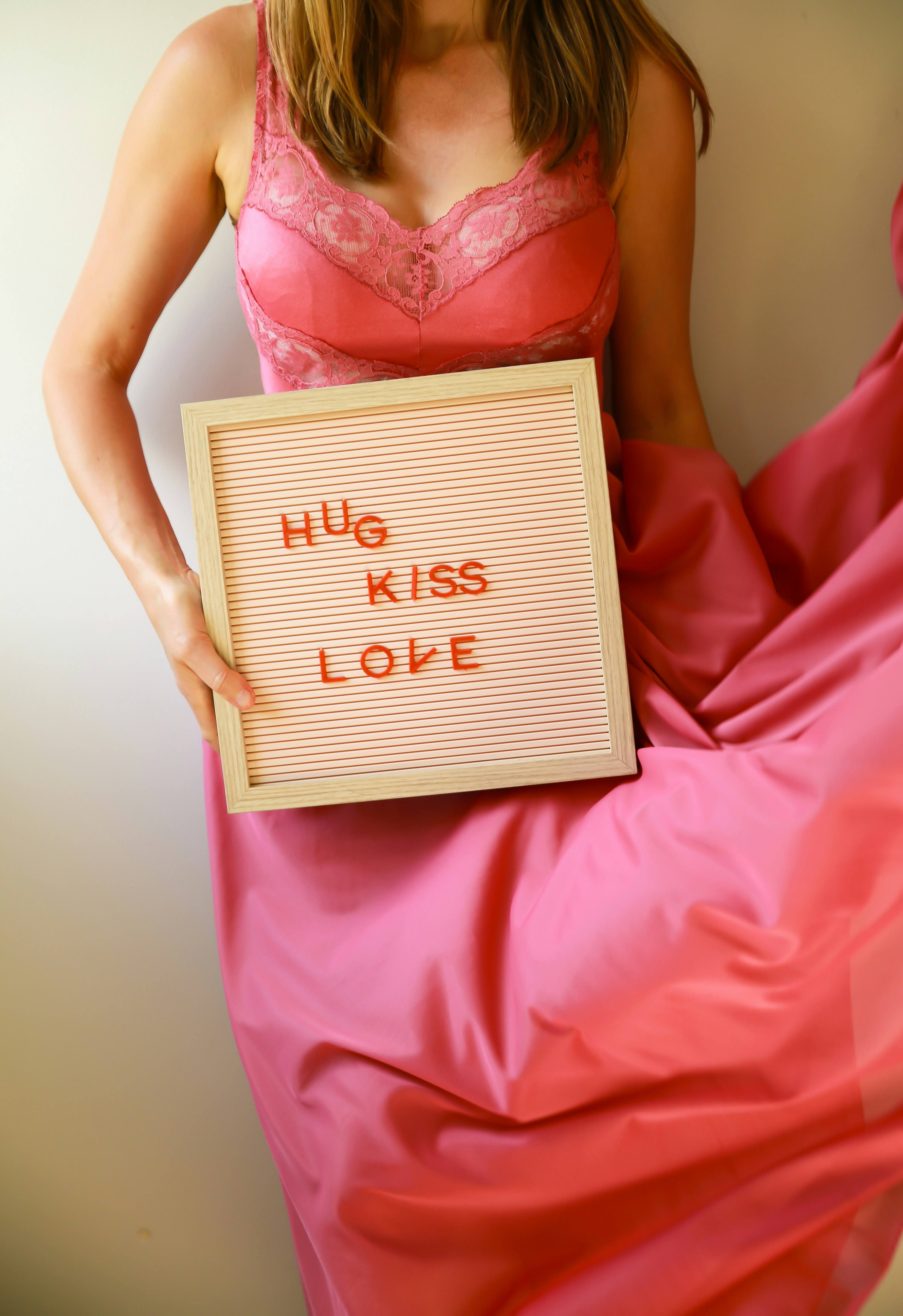 Woman holds a sign that reads "hug, kiss, love." photo – Free Woman ...