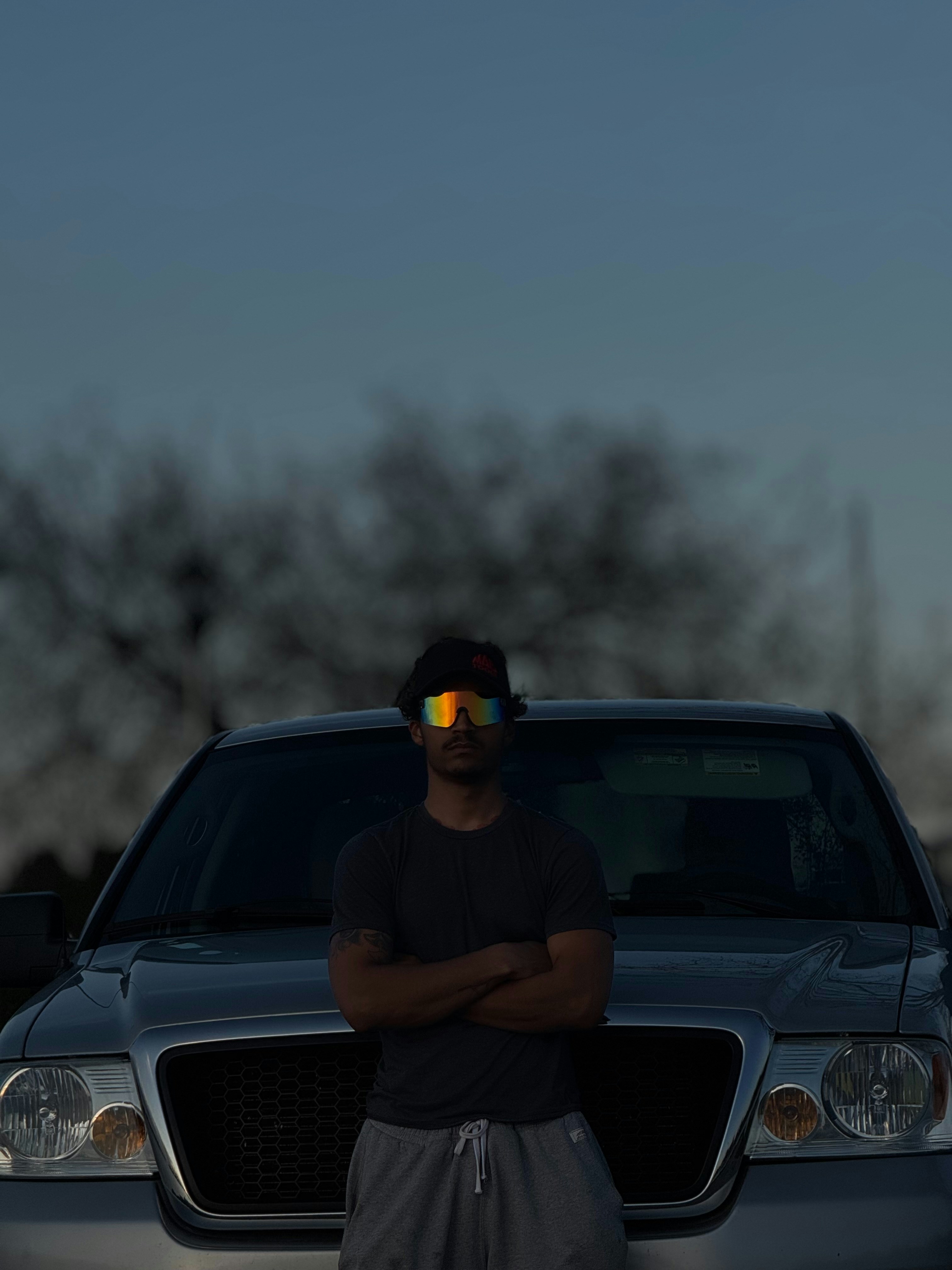 Blue-hour Gaze: A Man Paused Before a Chrome-Grilled SUV