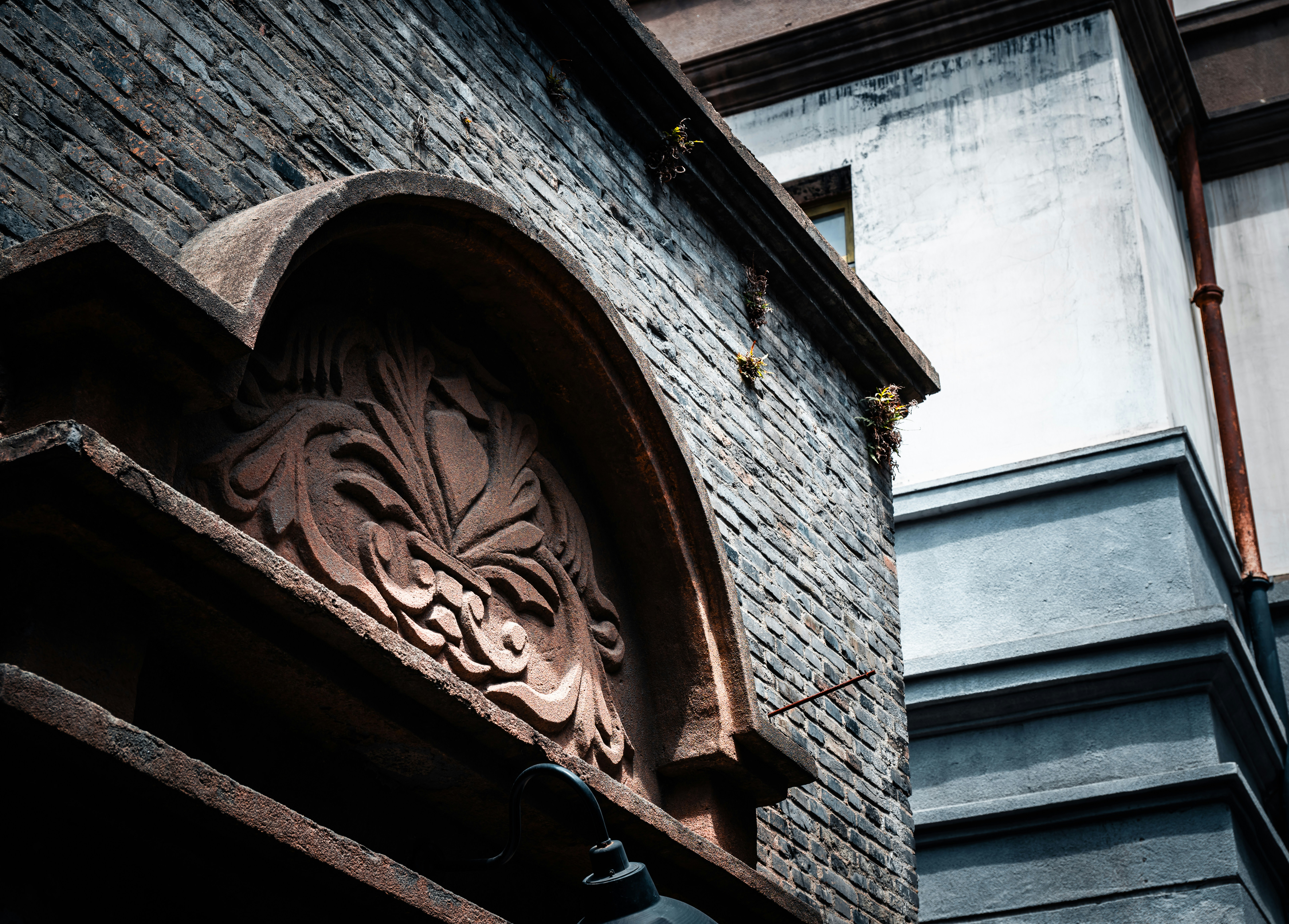 Ornate Arch Crest Framed by Weathered Brick Facade