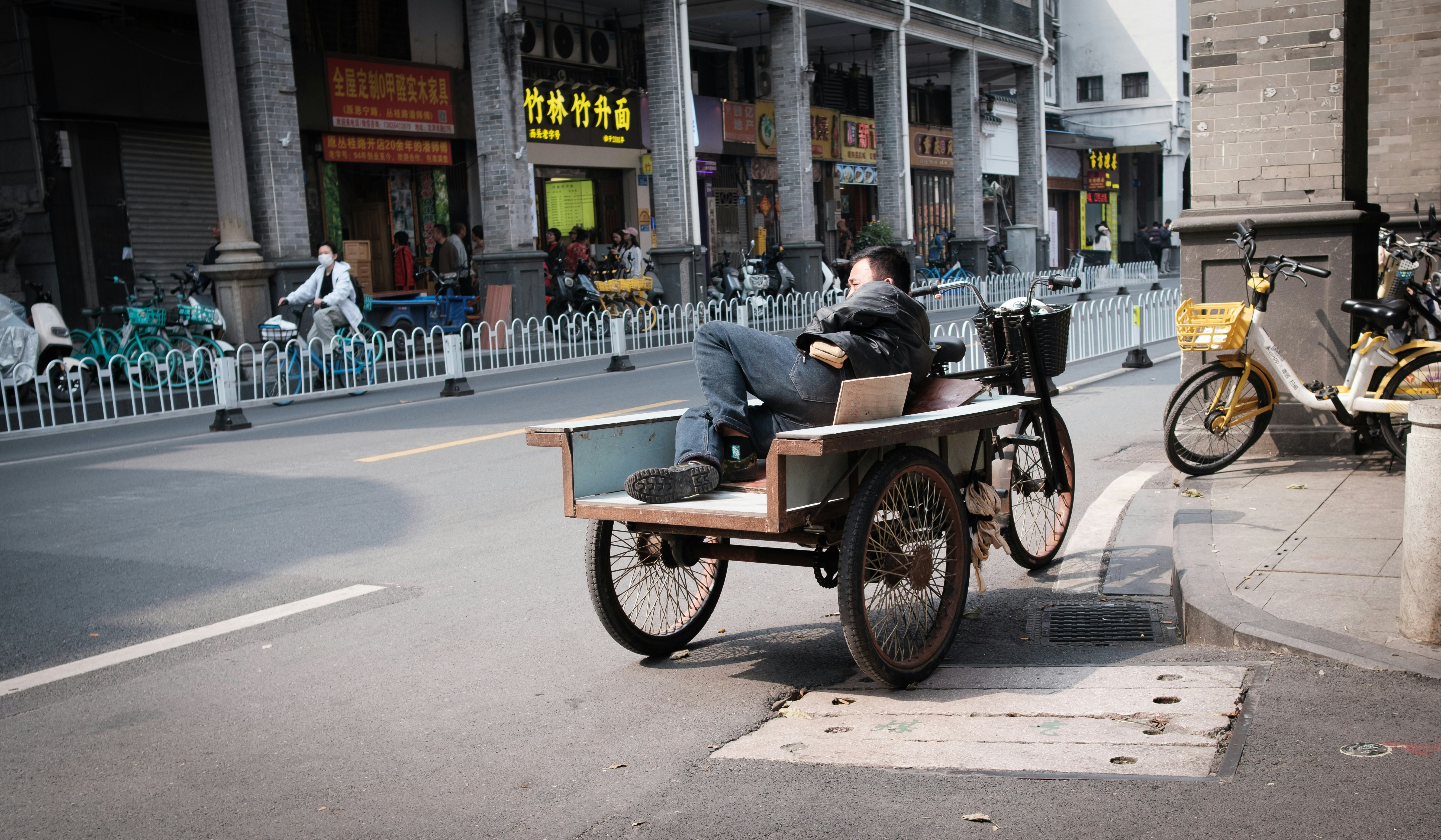 Quiet Repose in a Wooden Pedicab on a Bustling City Street