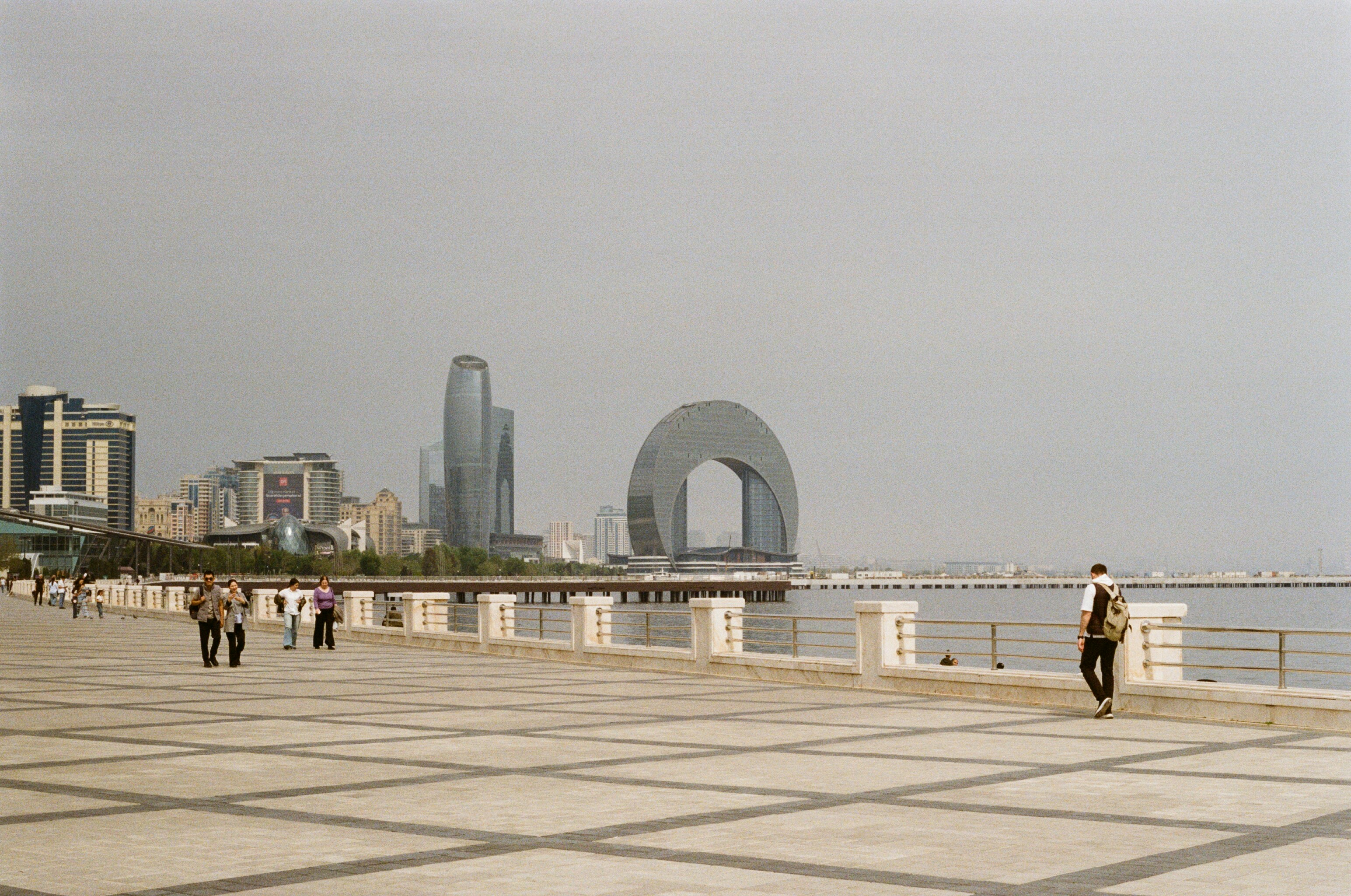 Circular Arch against the Skyline: A Quiet Promenade by the Waterfront