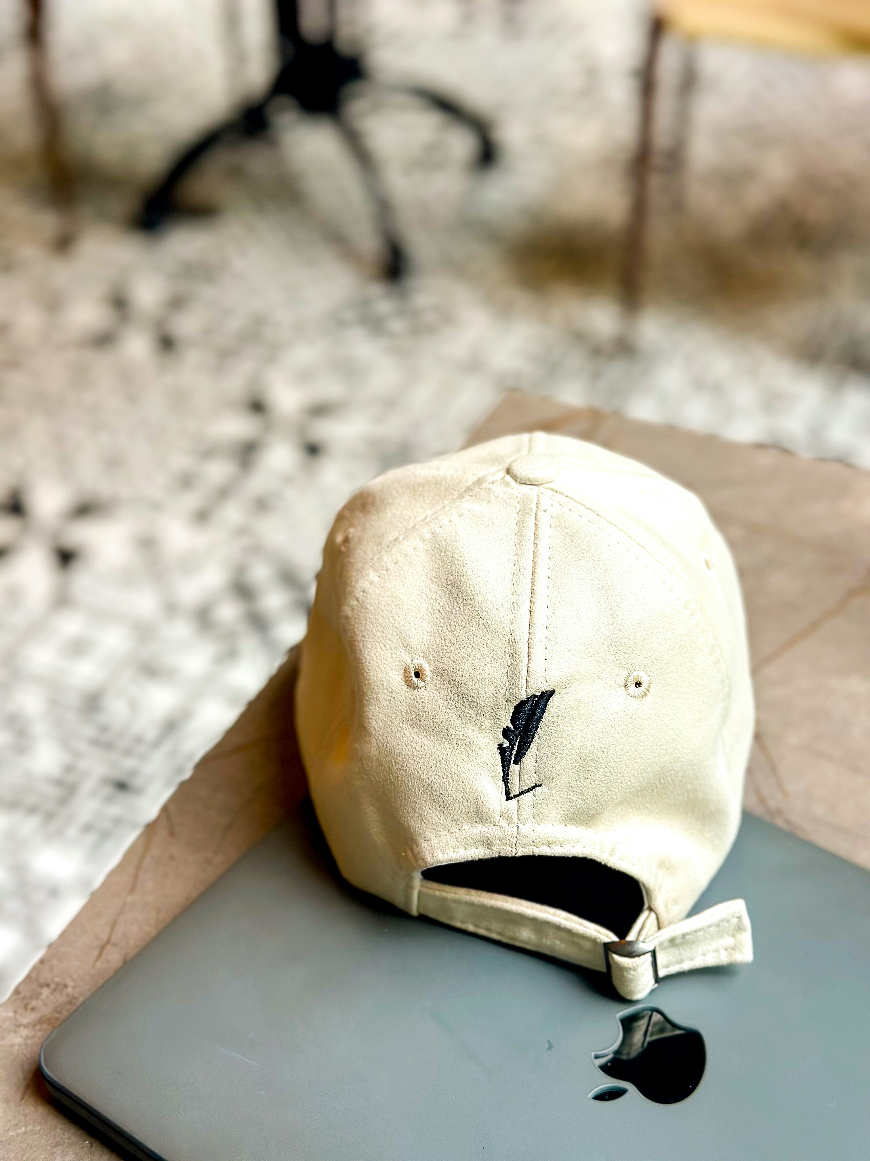 Beige Cap Resting on a Glossy MacBook: A Quiet Studio Moment