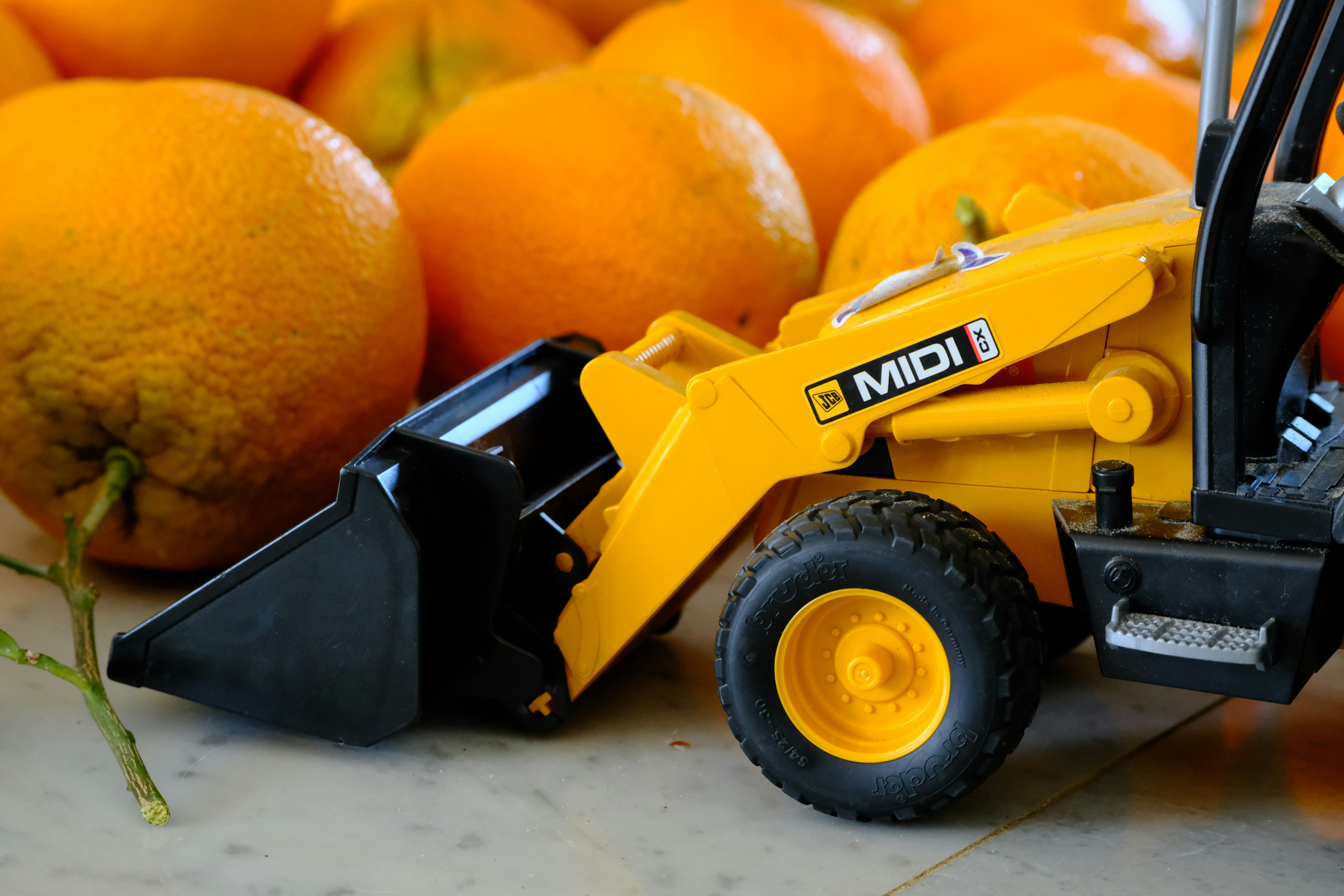 Miniature Yellow Loader Amid a Citrus Still-Life