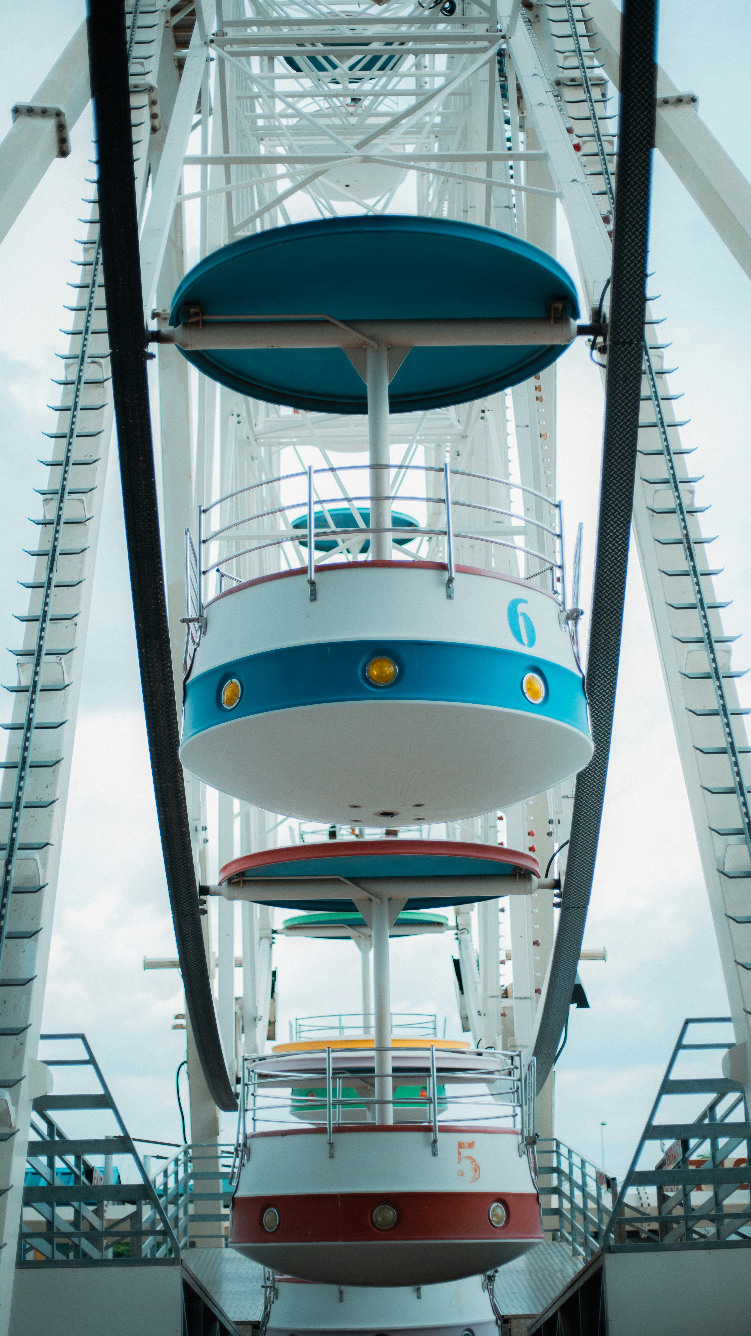 Midair Carousel: Blue Gondola Framed by the Ferris Wheel's Steel Spine