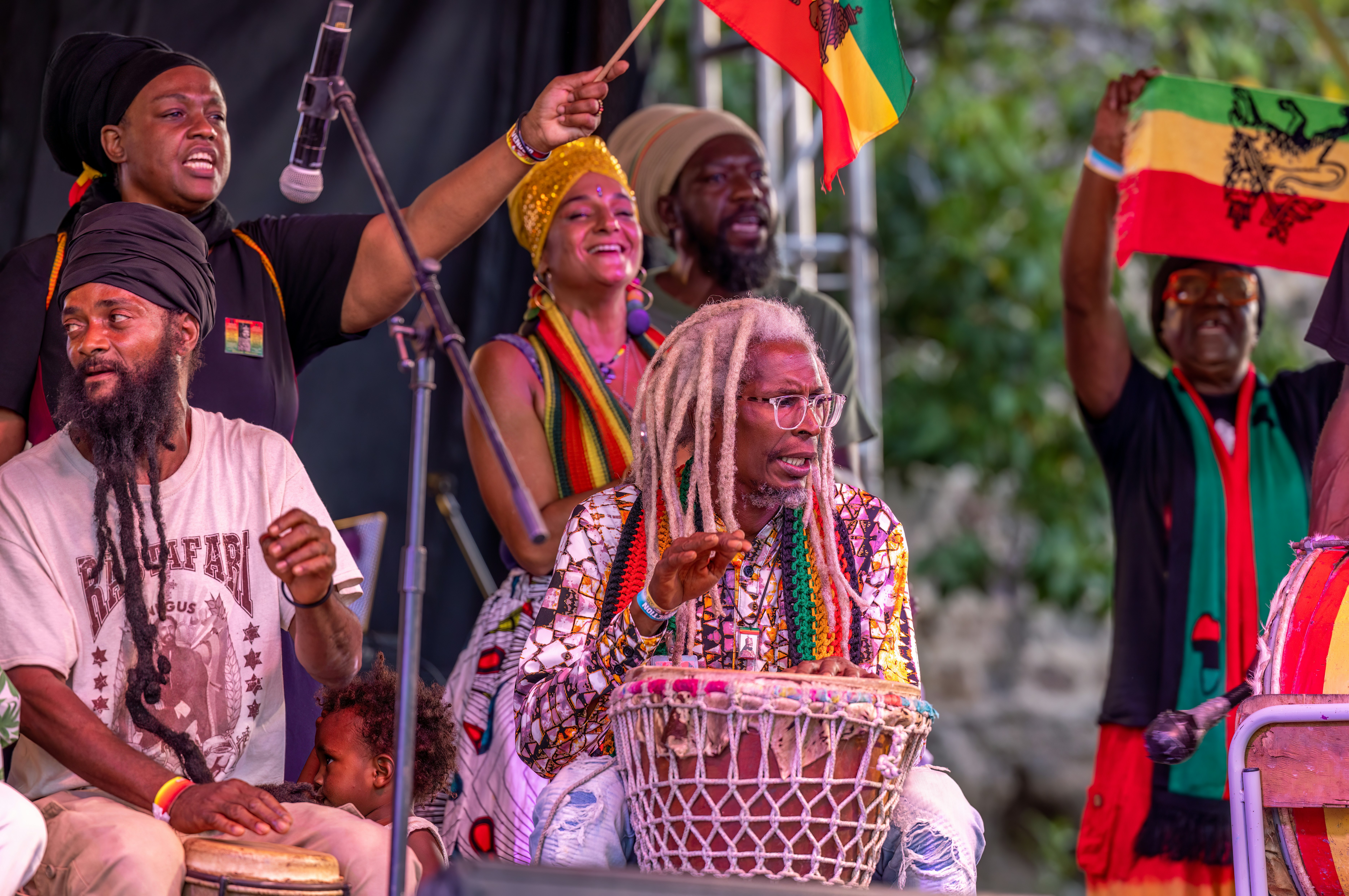 Reggae band performing on stage with flags. photo – Free Man Image on ...
