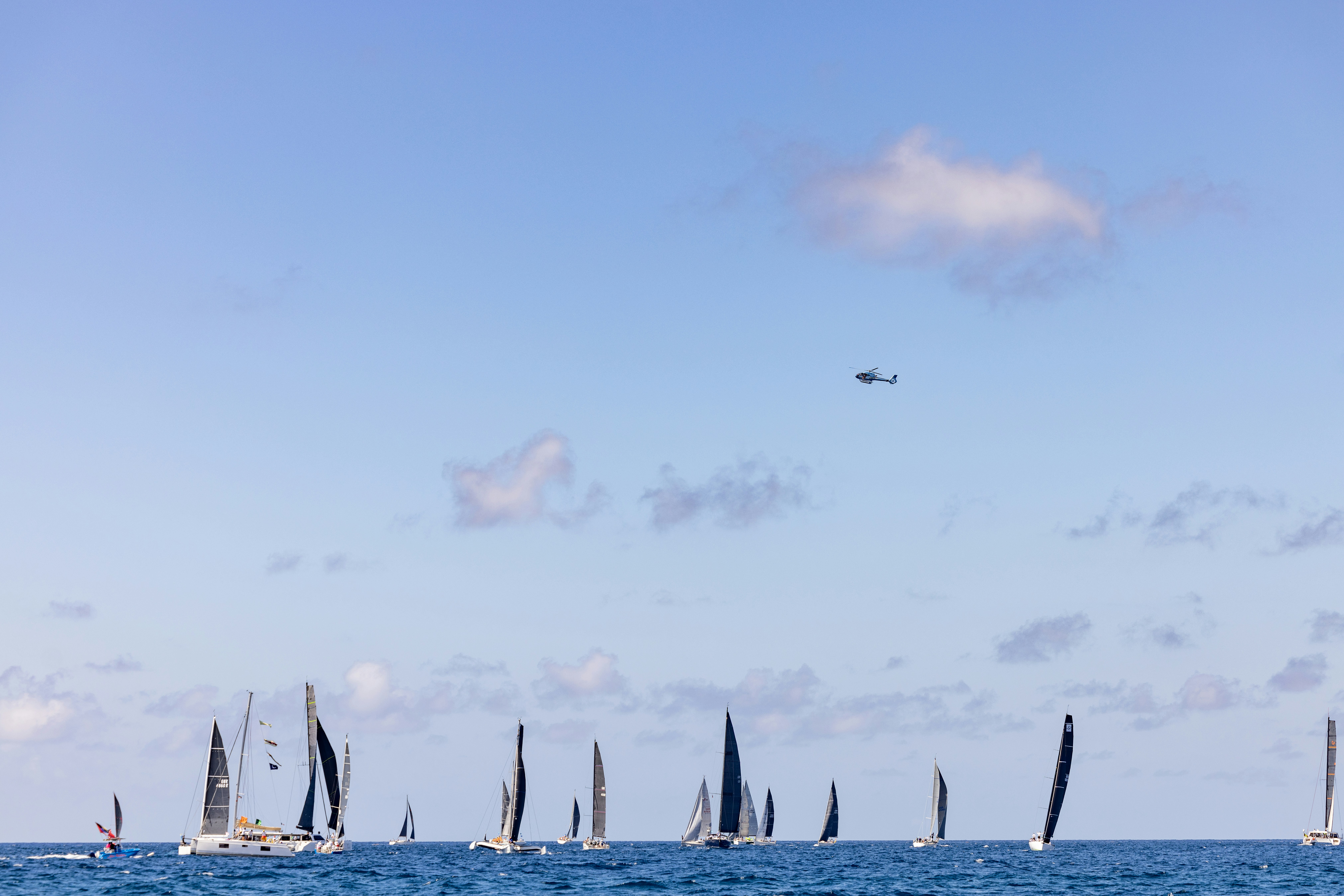 Sailors at Dusk: A Fleet of Tiny Ribbons on a Calm Sea