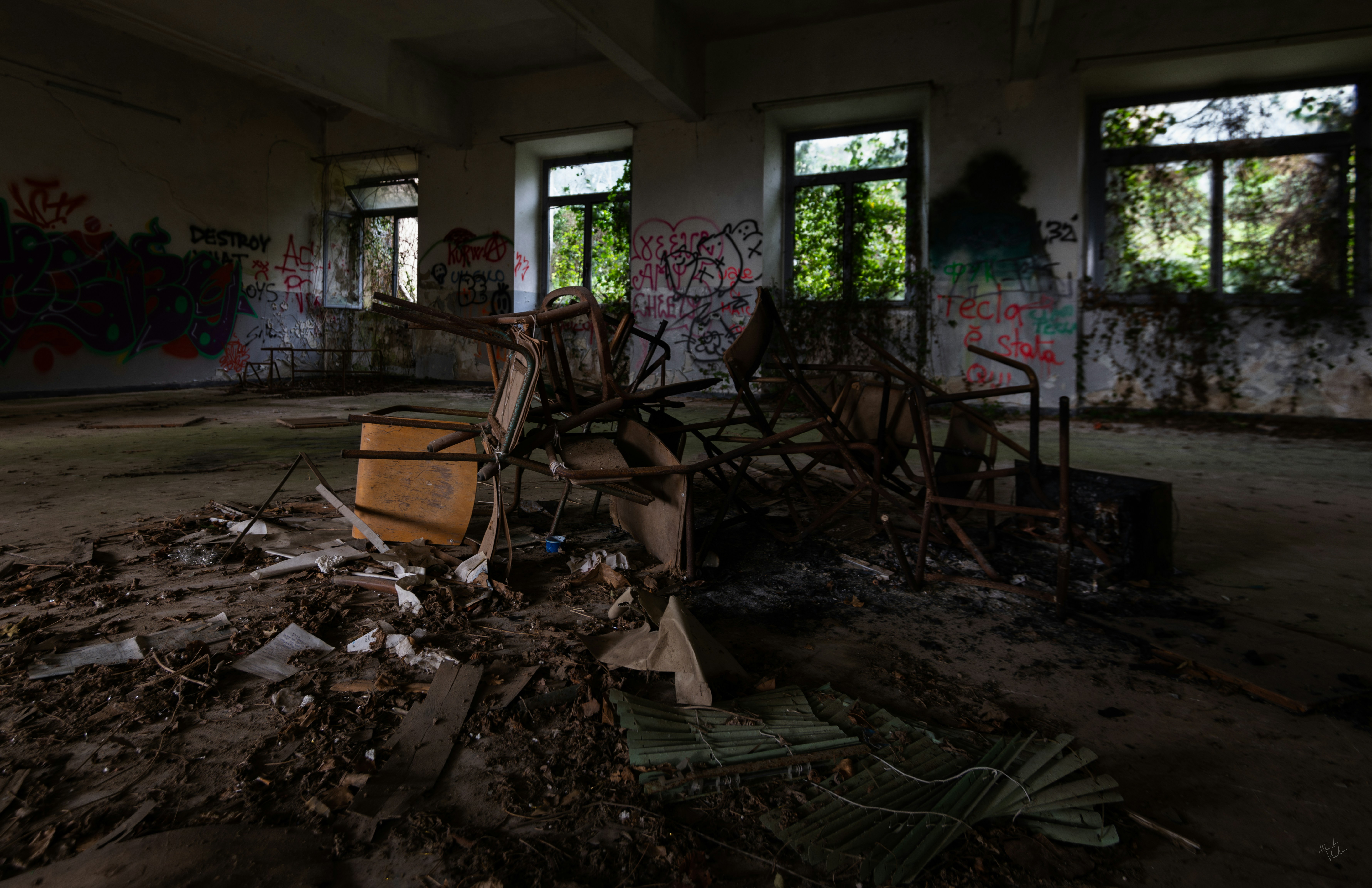 A derelict room with graffiti and debris.
