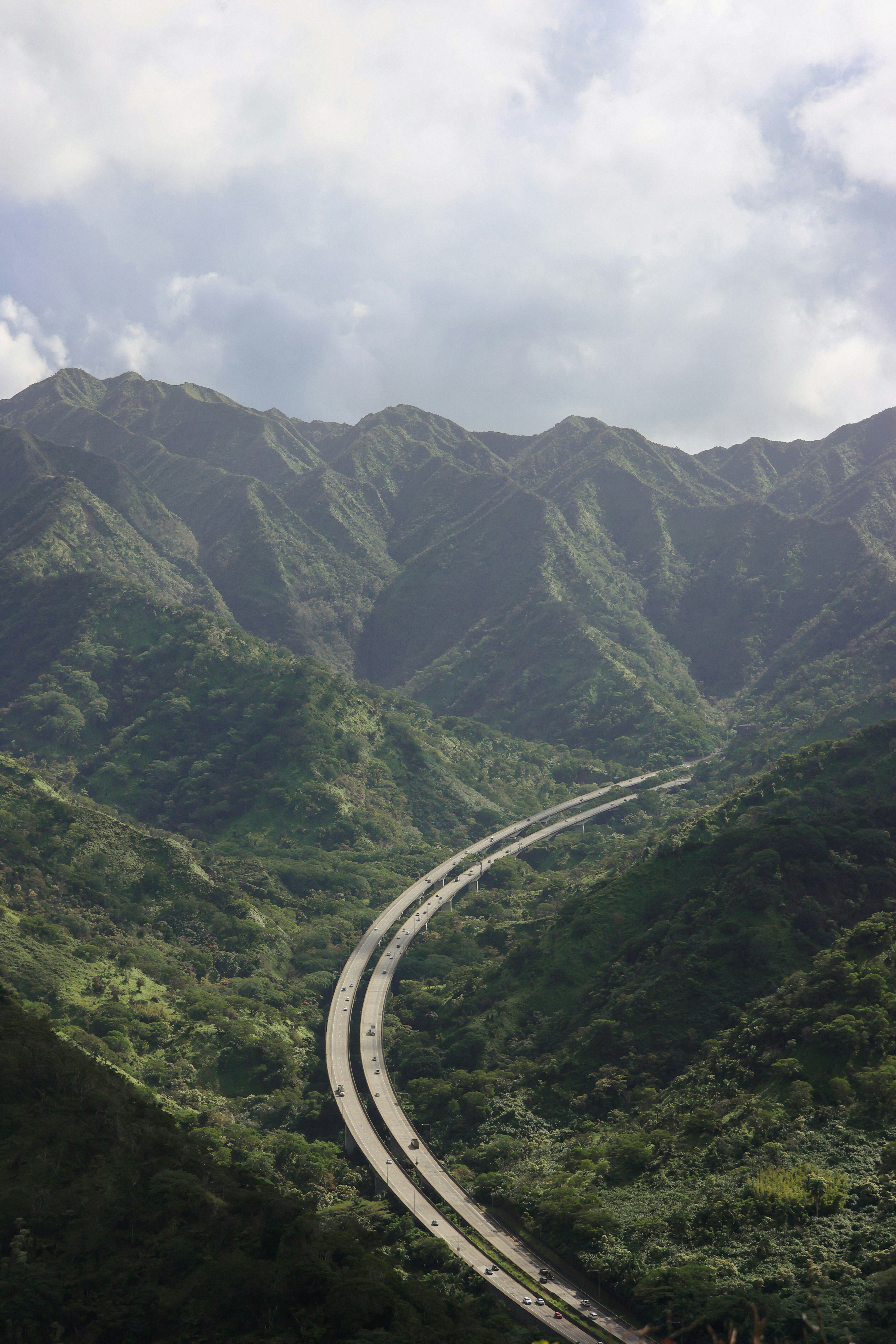 Road winding through mountains under a cloudy sky. photo – Free United ...