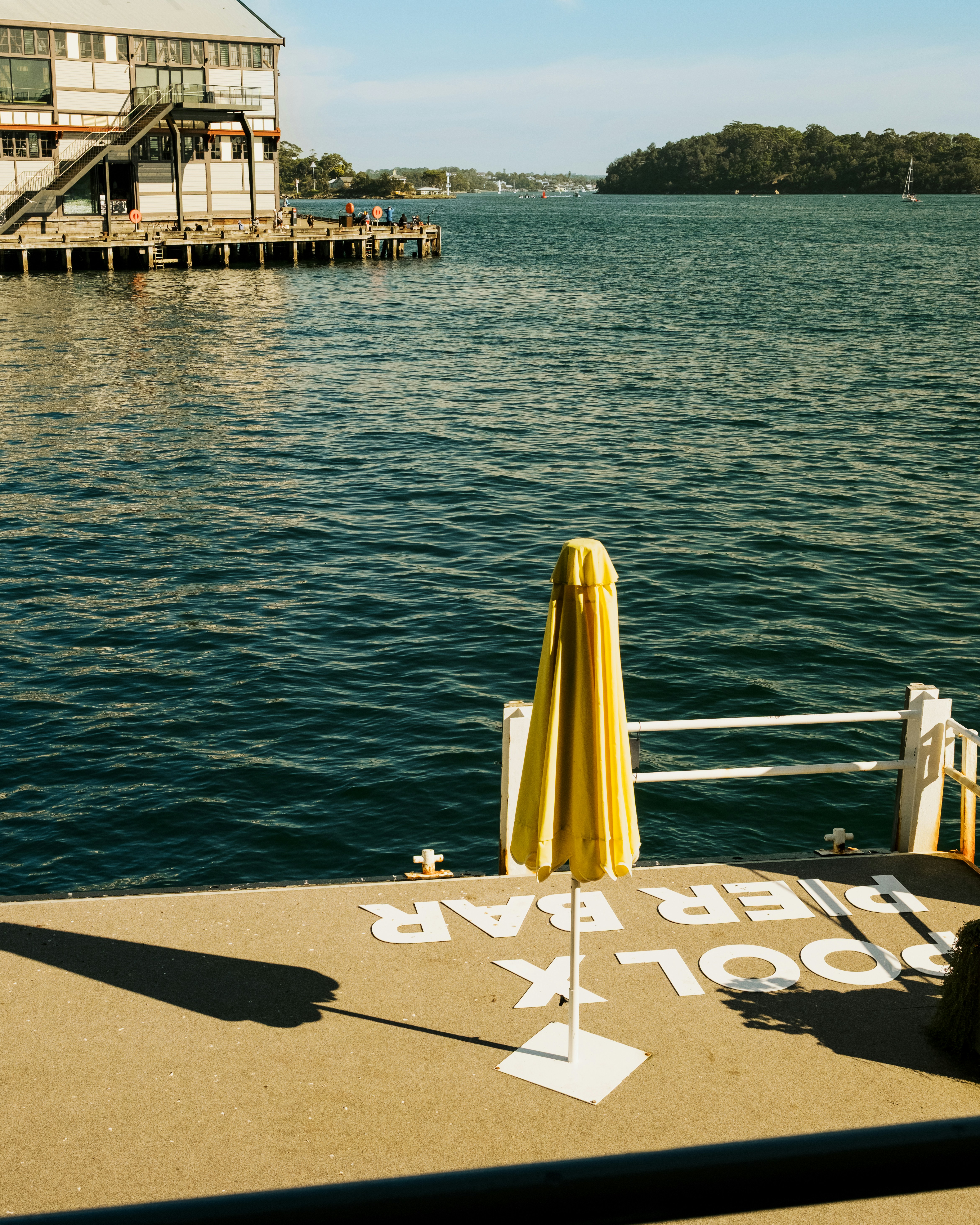 Harbor Pause: The Yellow Umbrella Framing a Seaside Moment