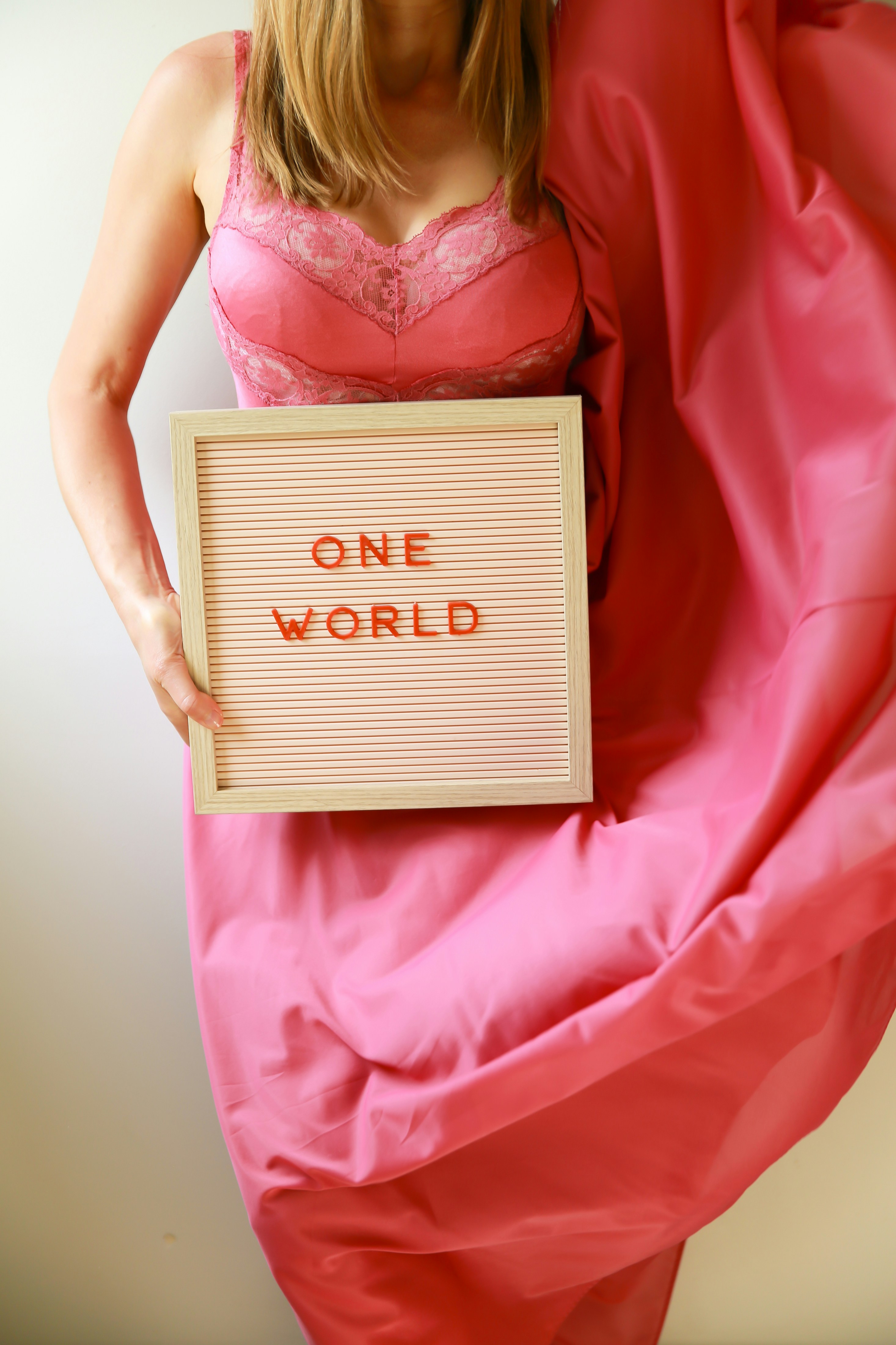 Woman holds a sign that says "one world". photo – Free Woman Image on ...