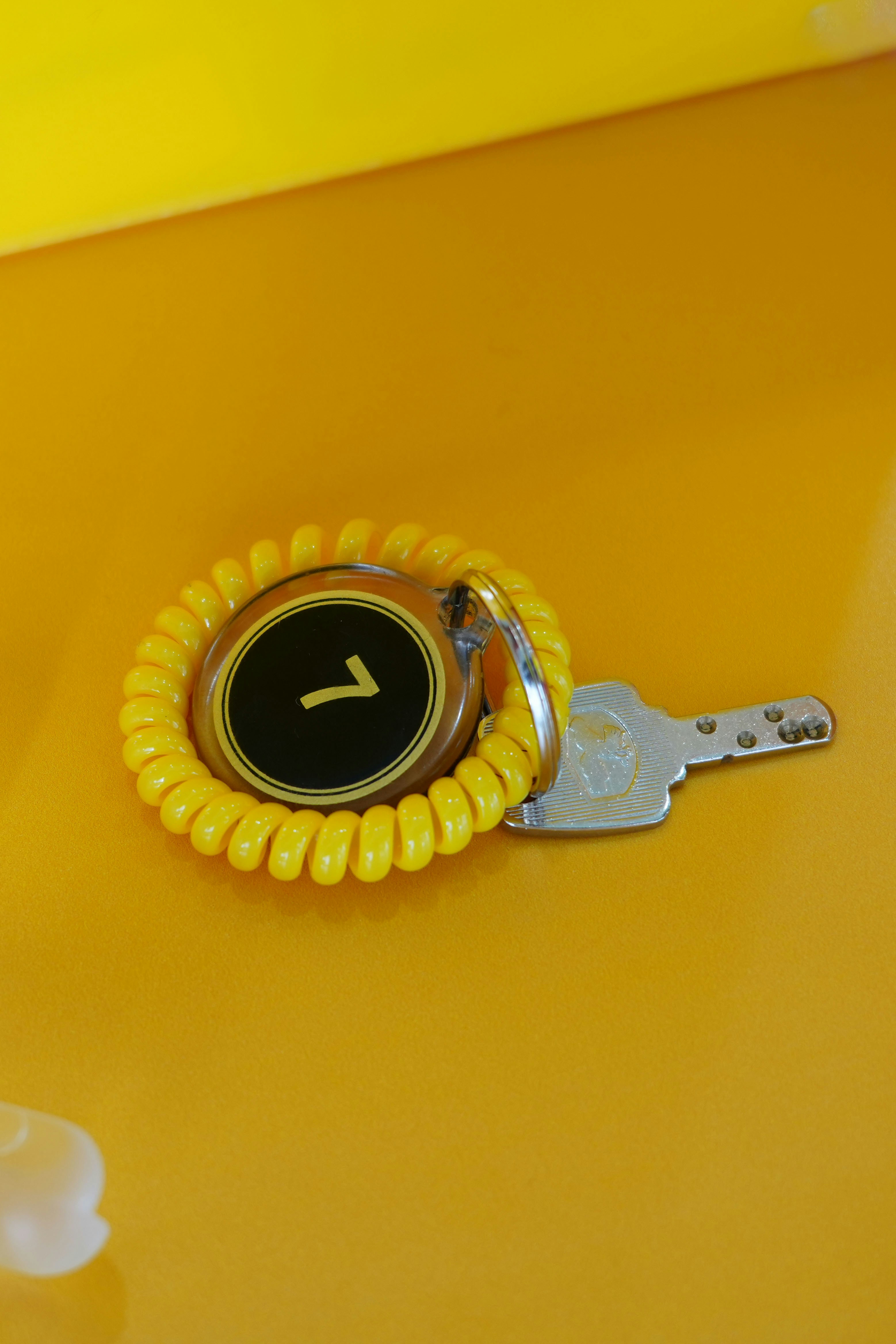 Yellow Coiled Keychain Encircling a Bold '7' Dial on a Sunlit Surface