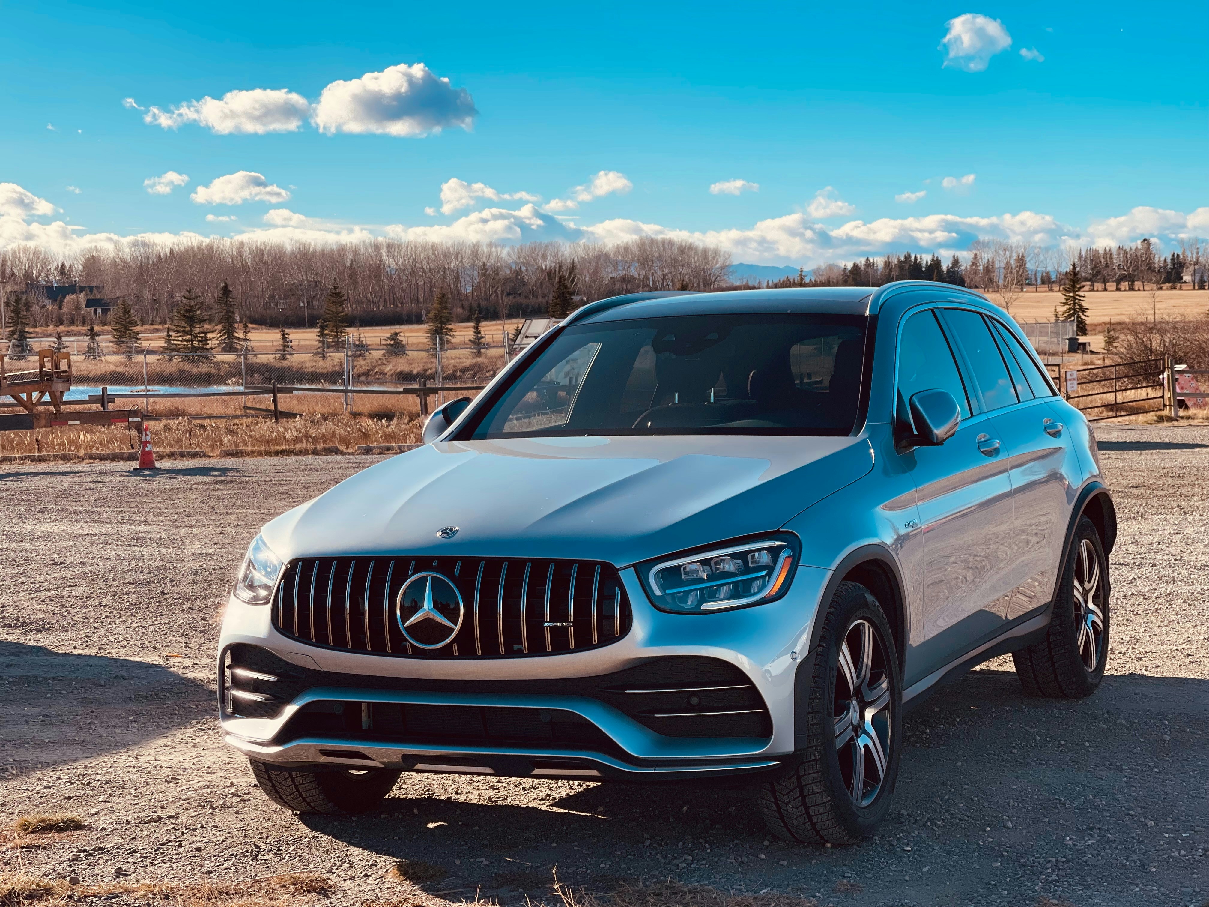 Silver Mercedes-Benz SUV on a sunlit gravel lot beneath a crystal-blue sky