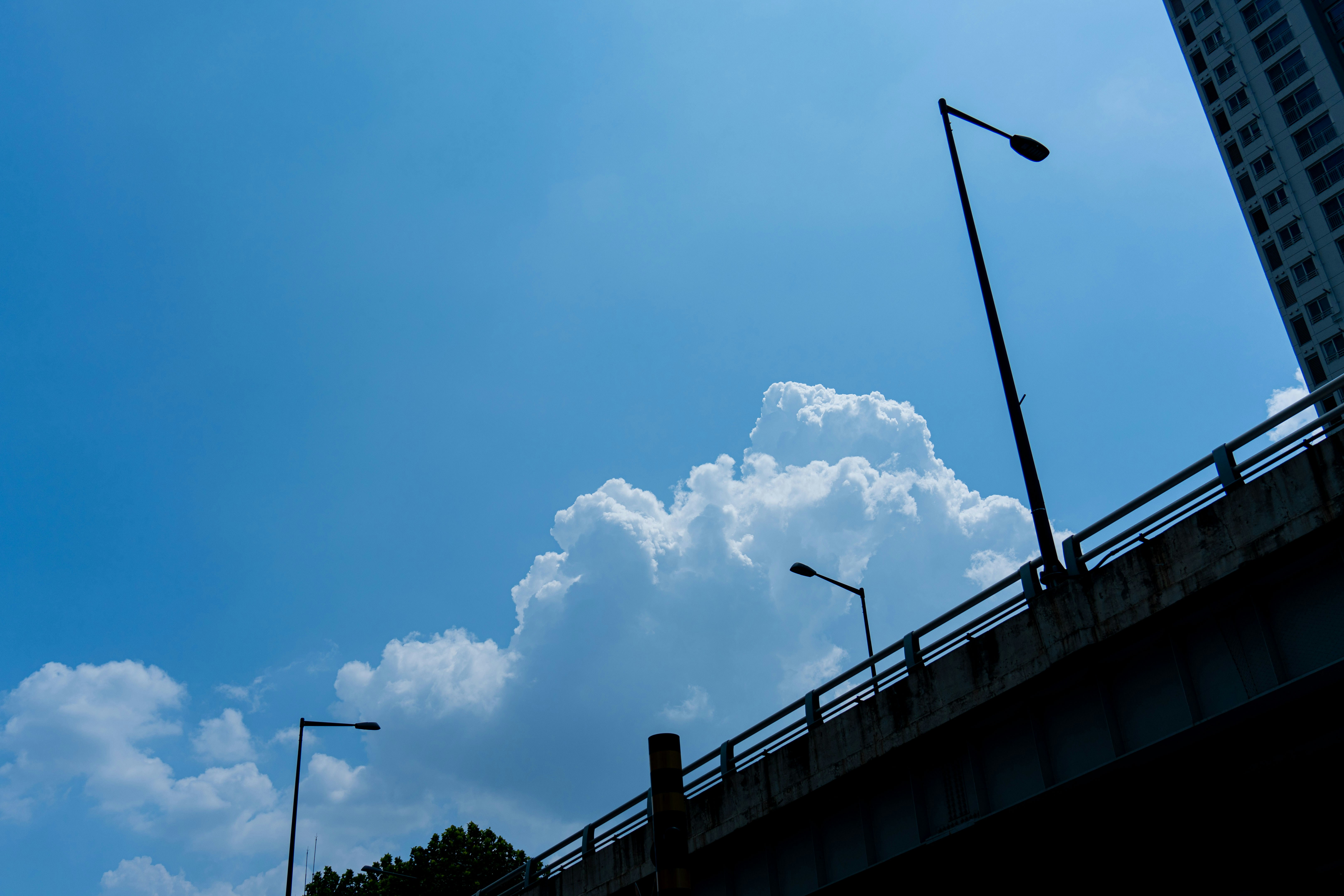 Azure Overpass: Quiet Skyline Under Puffy Clouds