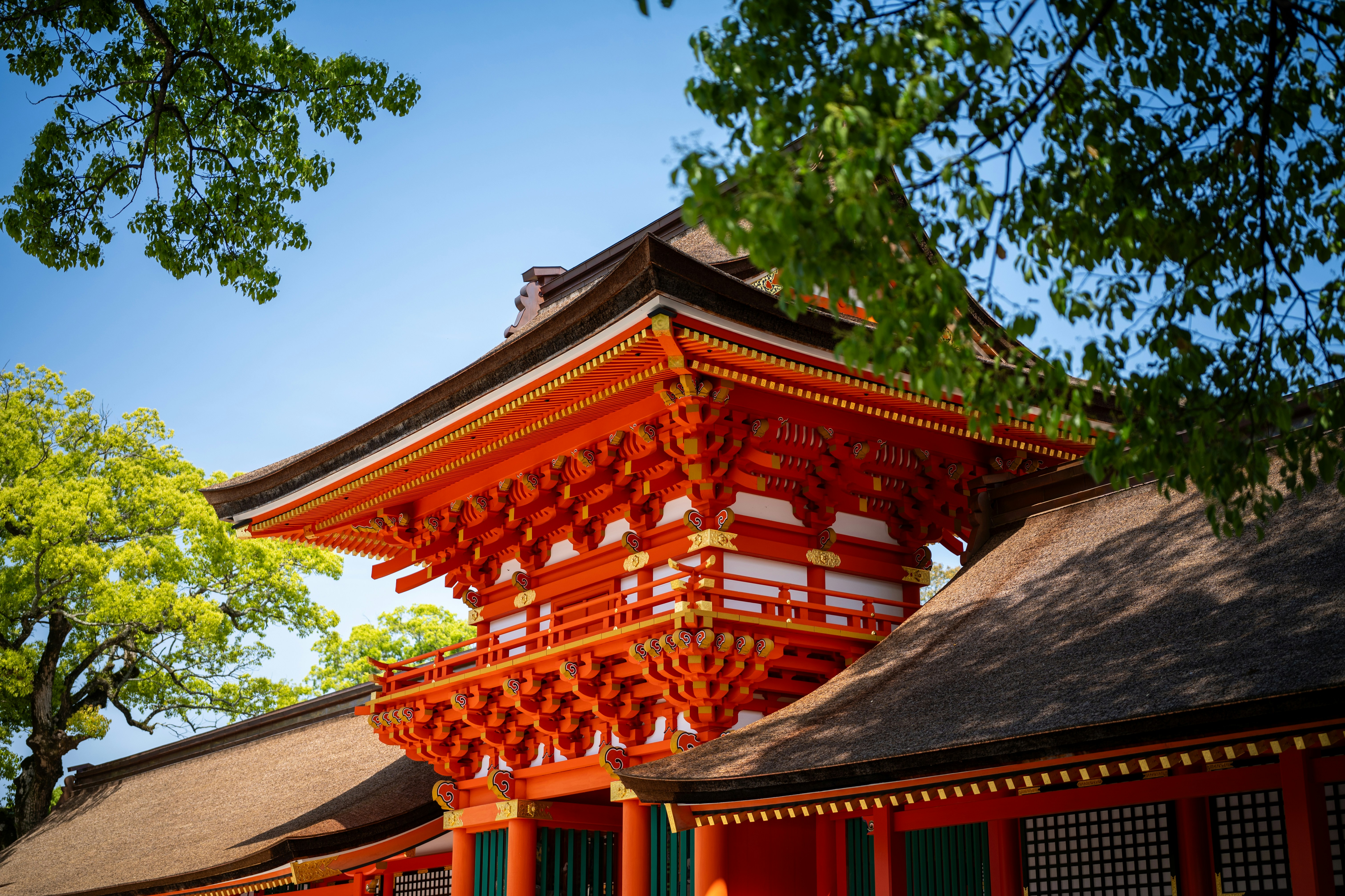 A vibrant, orange japanese temple sits beneath the blue sky. photo ...
