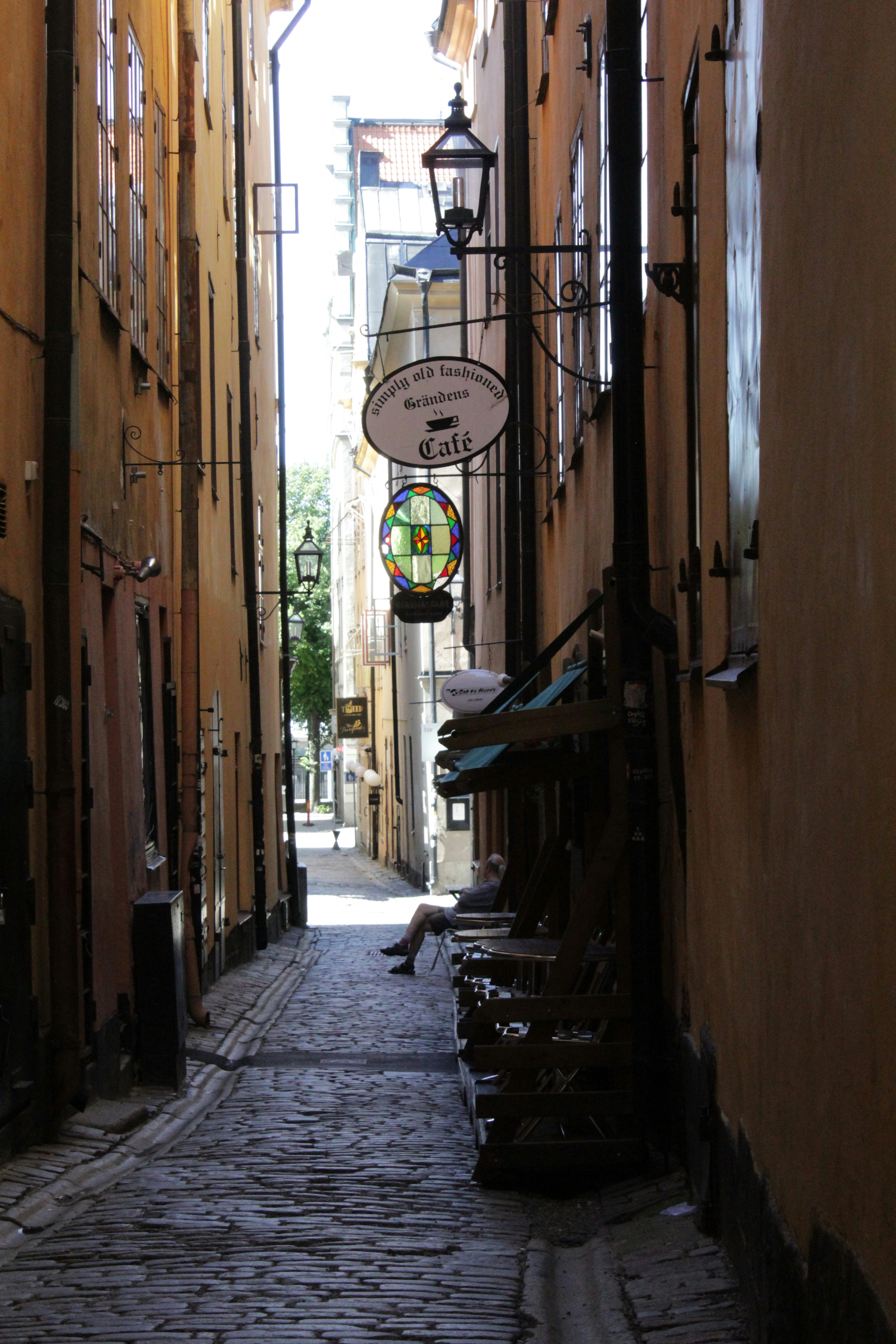 A narrow, cobbled alleyway with shops and a cafe. photo – Free Sweden ...