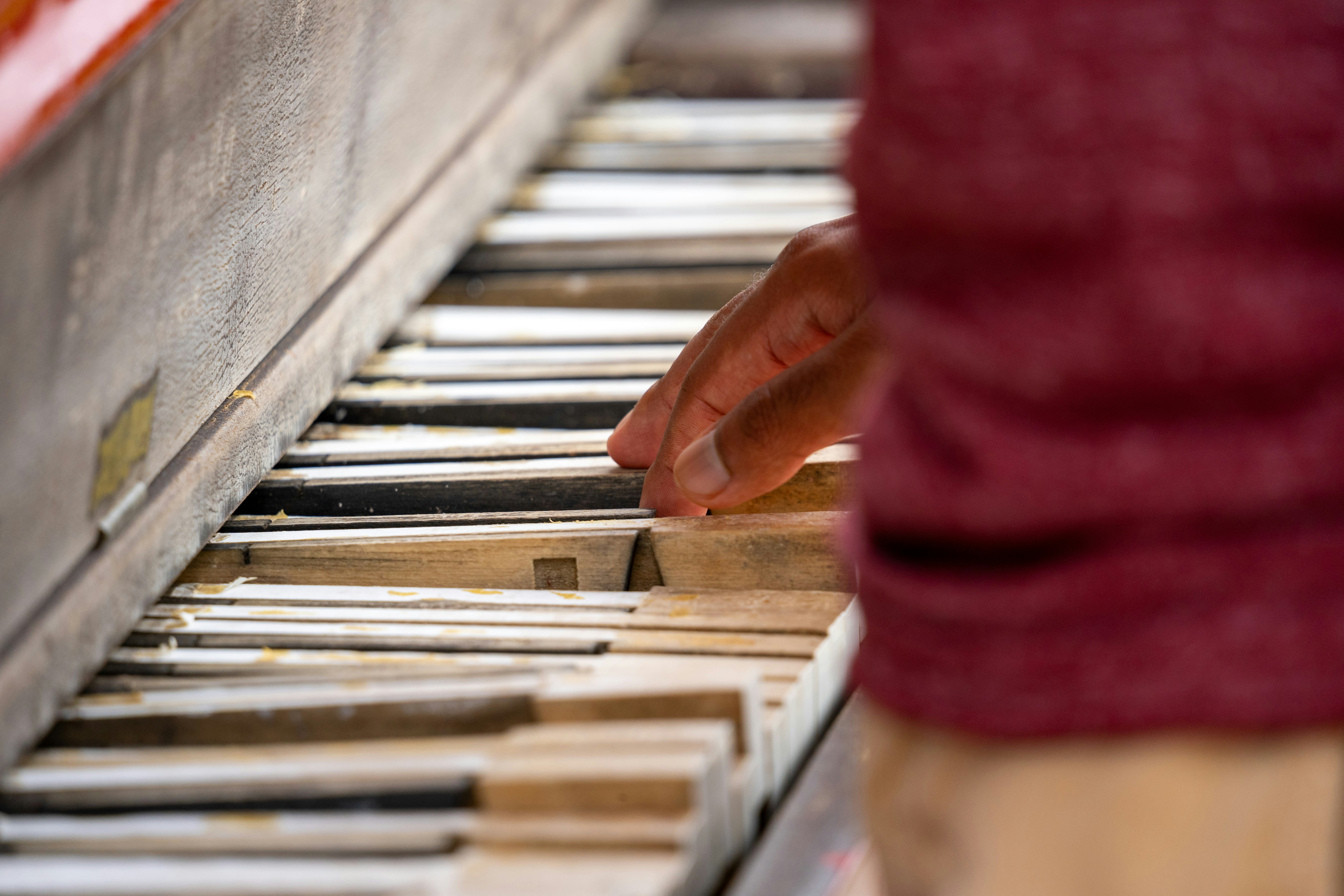 Hands in Motion on a Weathered Piano Keyboard