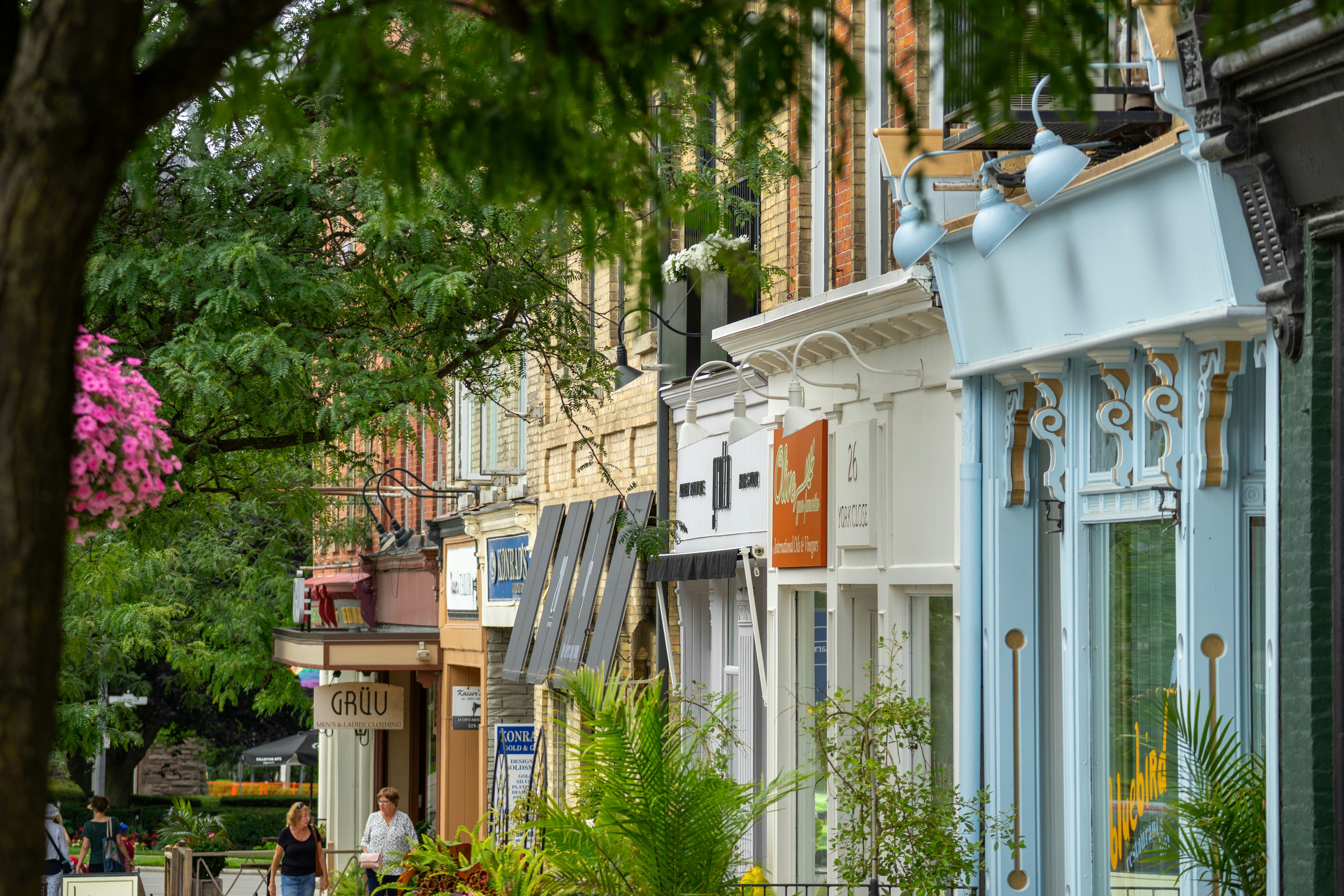 A row of quaint shops lines a city street. photo – Free Canada Image on ...