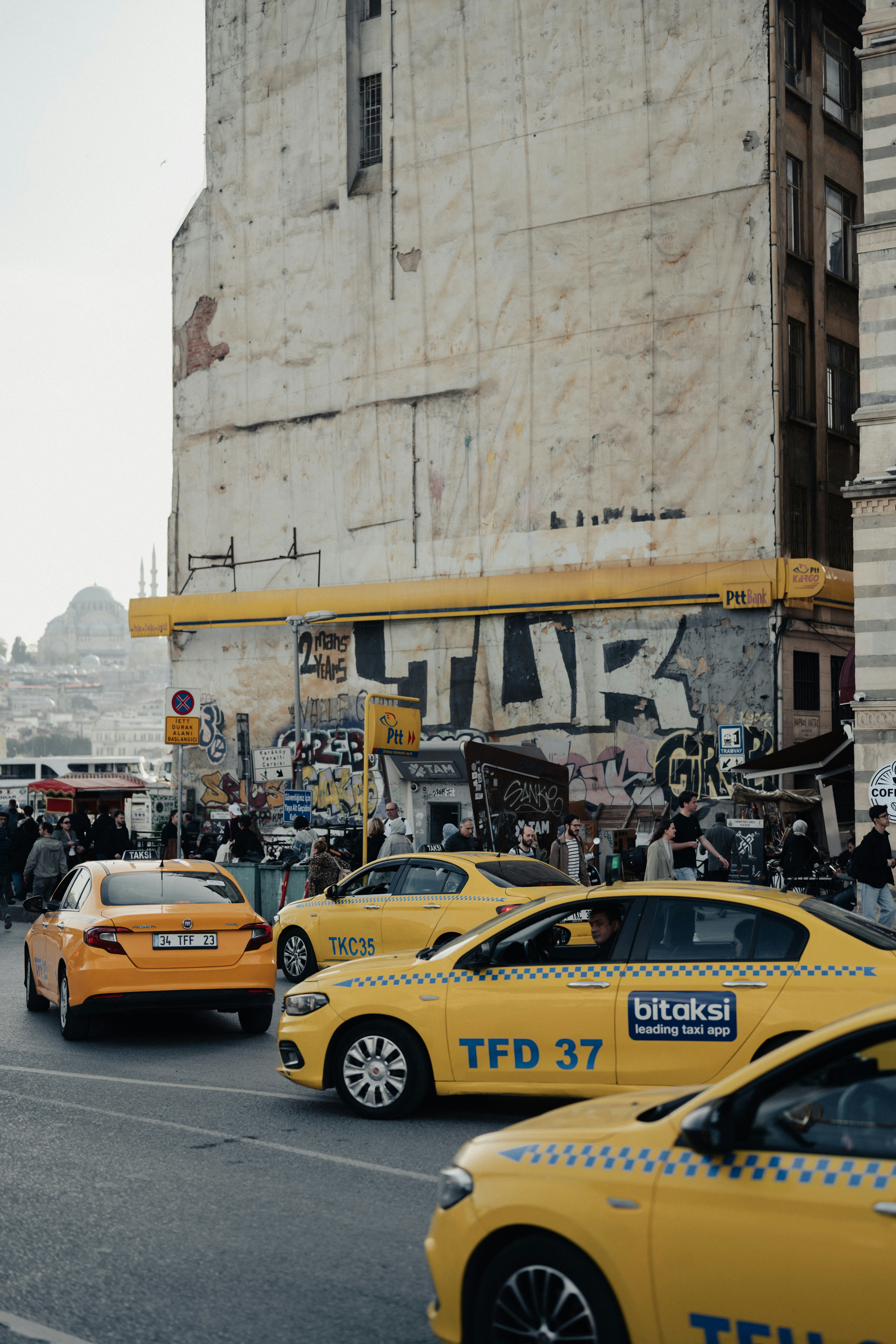 Yellow taxis are driving in front of a city building. photo – Free ...