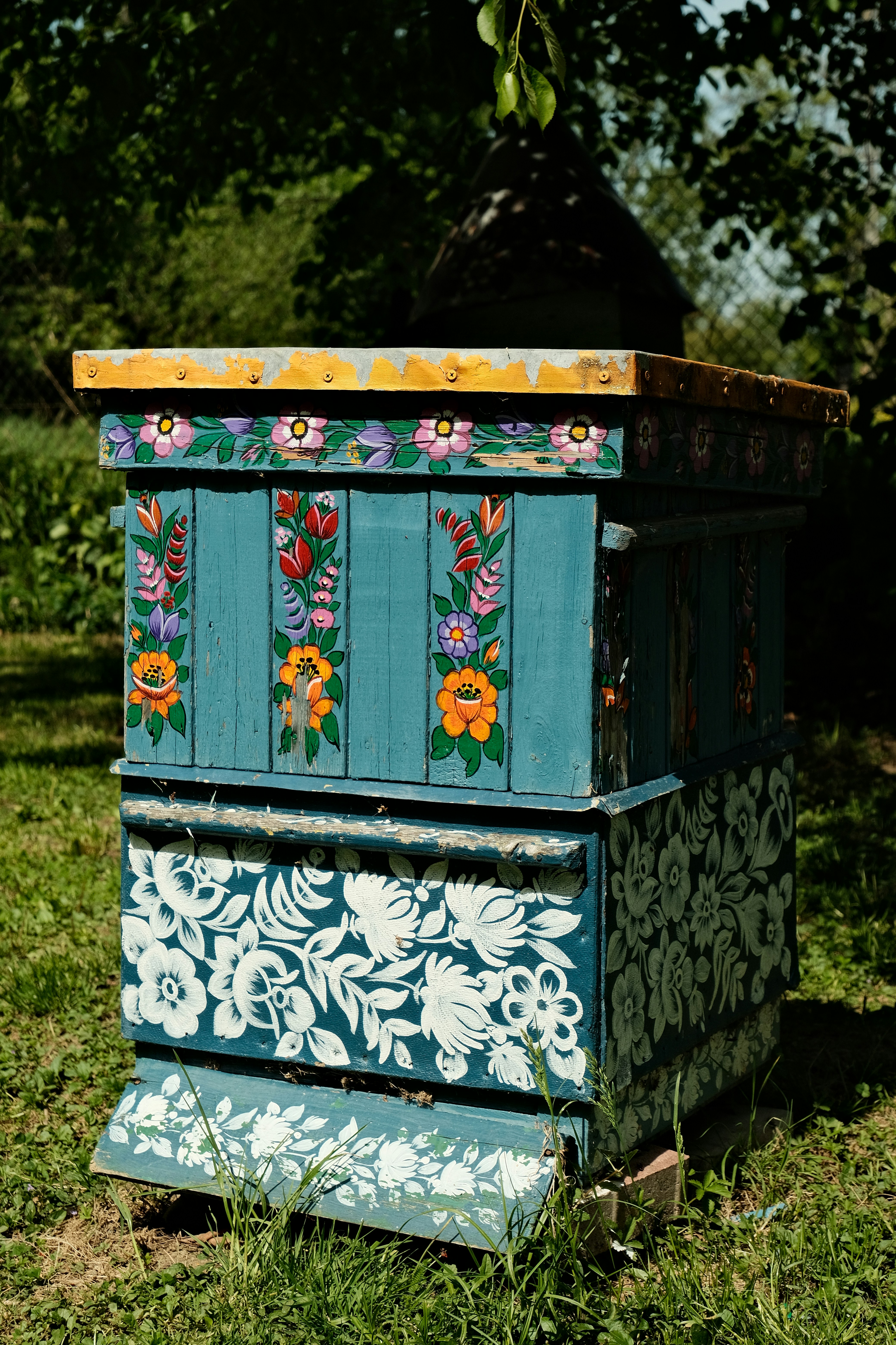 A brightly painted beehive stands outdoors. photo – Free Image on Unsplash
