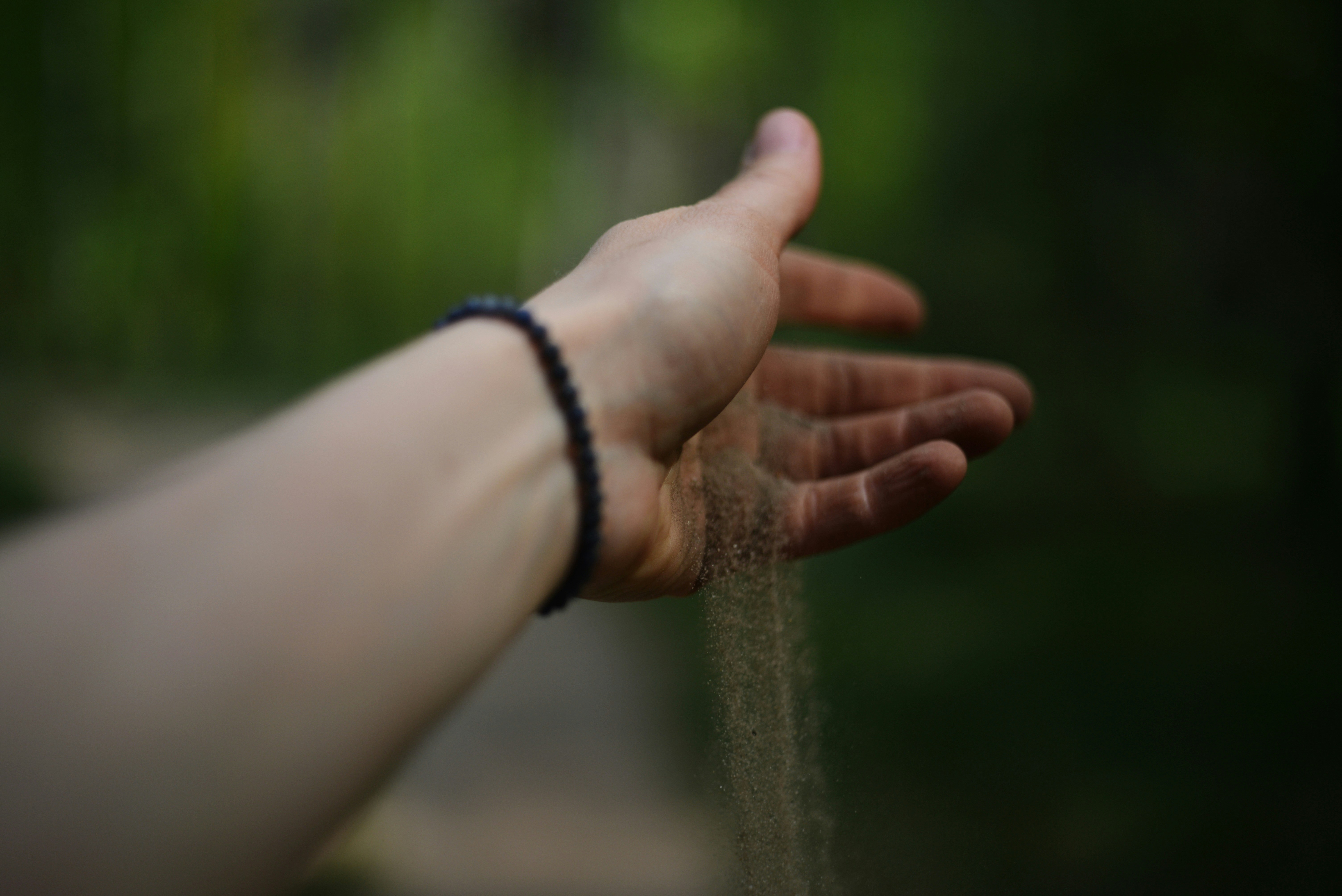 Sand pours from a hand in a blurred image.