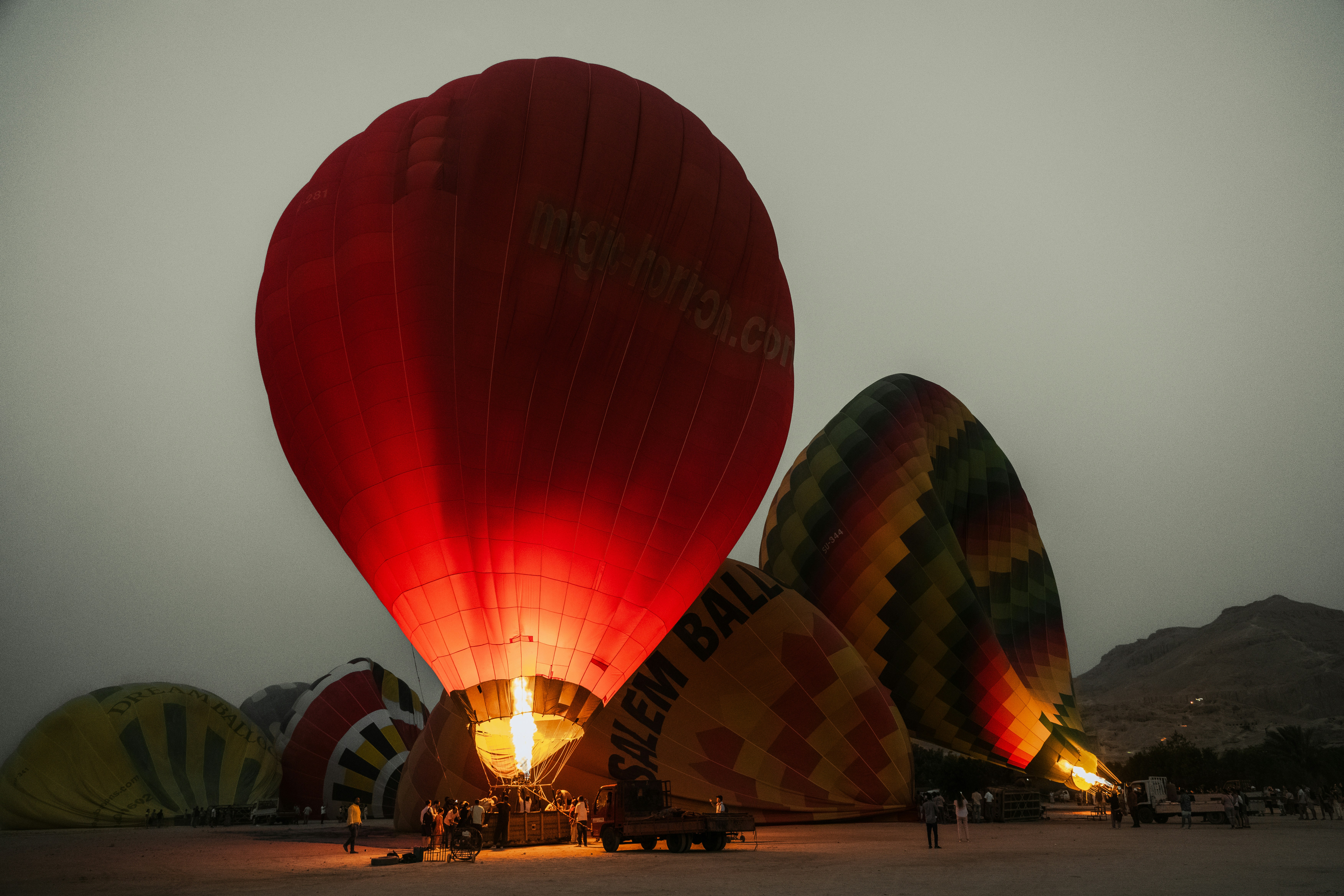Crimson Giant Under Firelight: Balloons Fill a Dusk-Glow Field