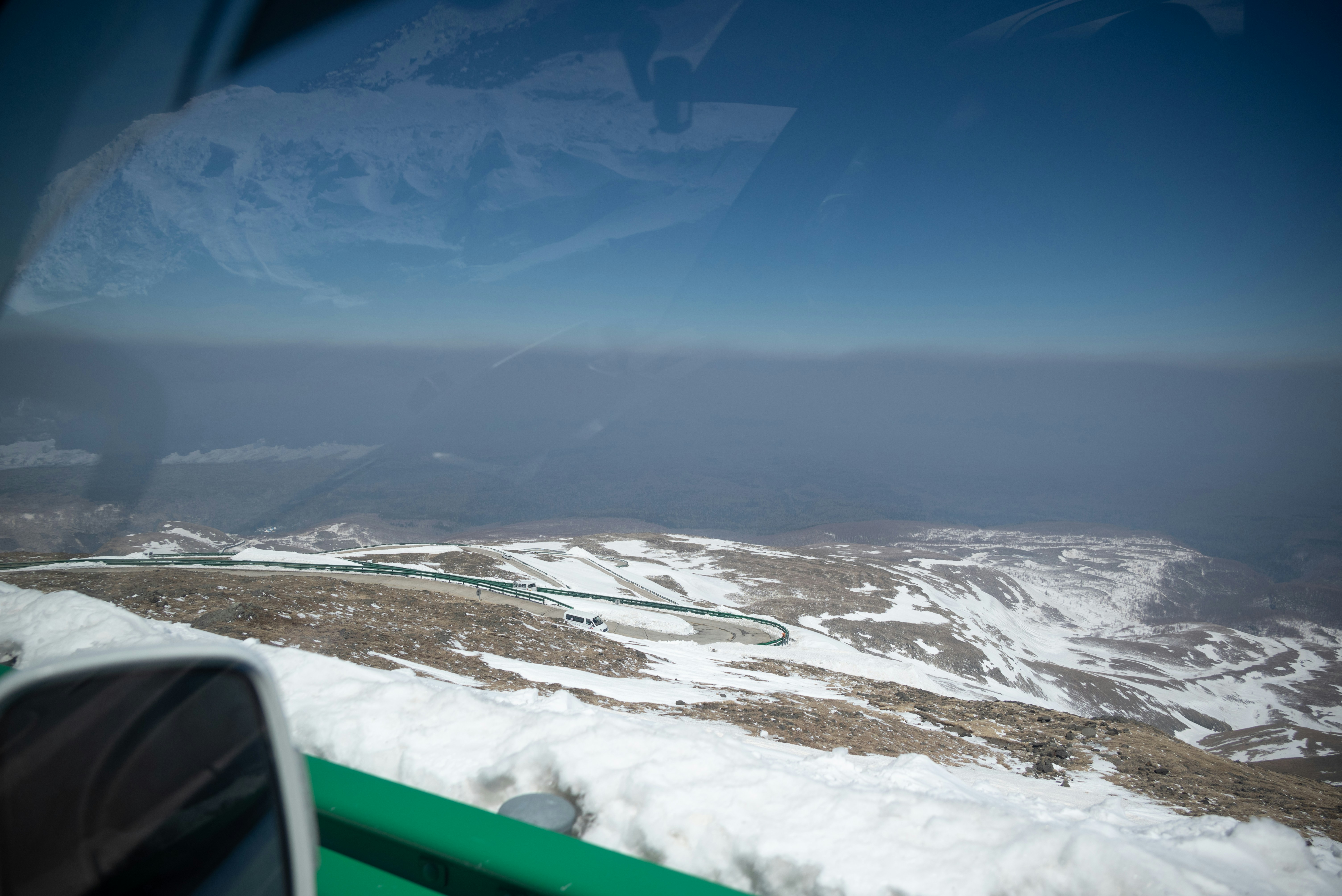 Snowy Alpine Descent Through a Windshield Frame