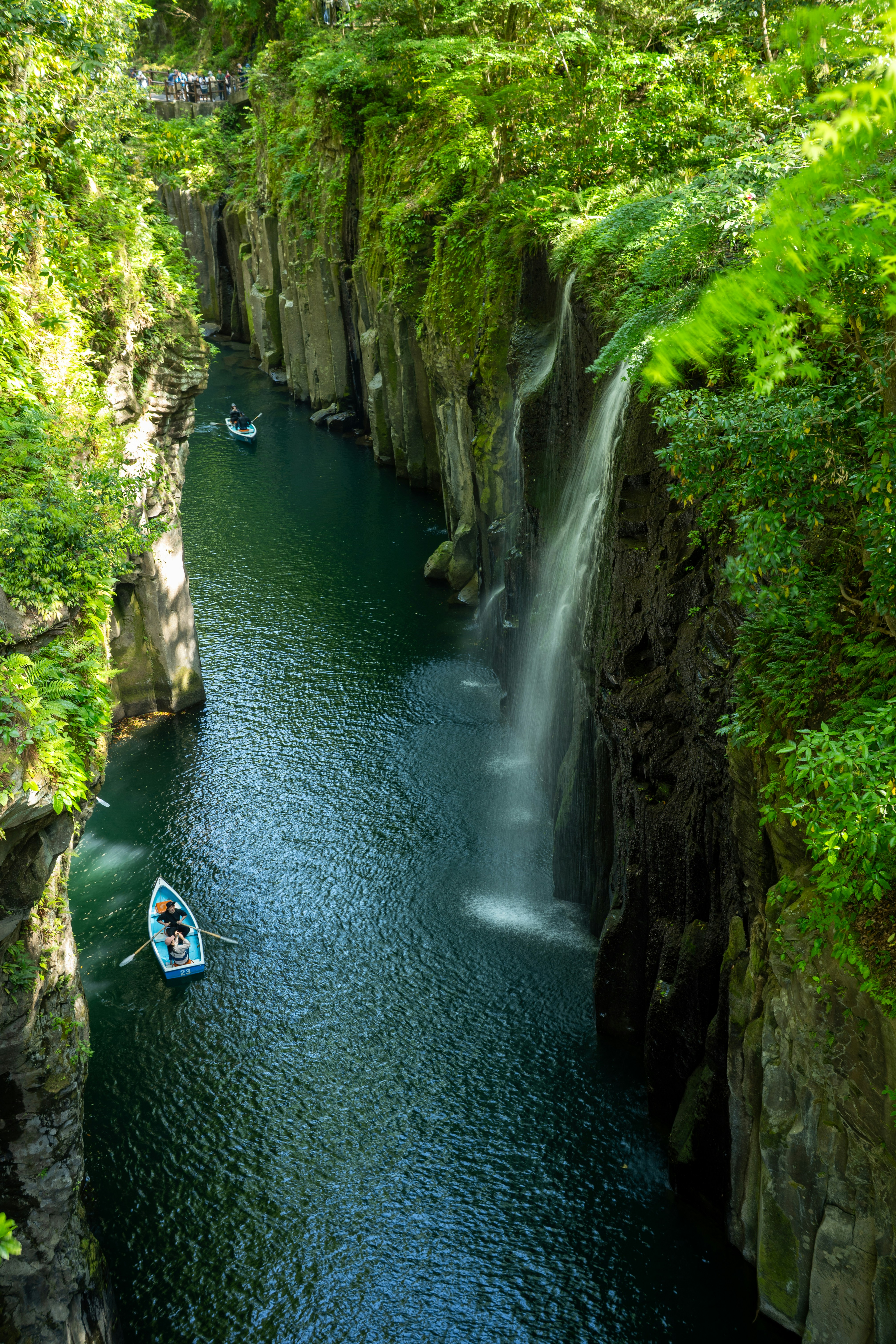 Boats navigate a scenic gorge with a waterfall. photo – Free Forest ...